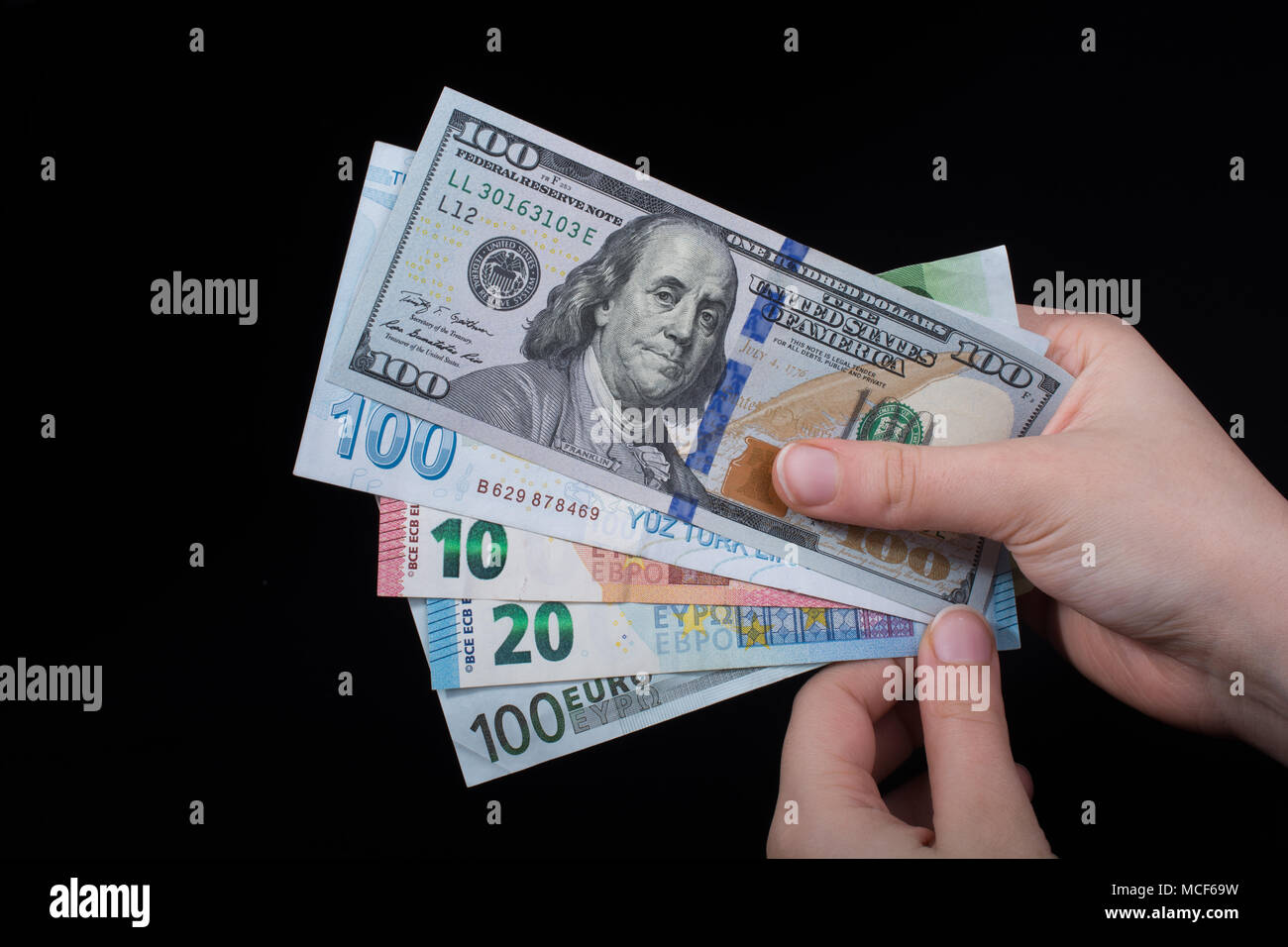 Hand holding American dollar banknotes isolated on black background ...