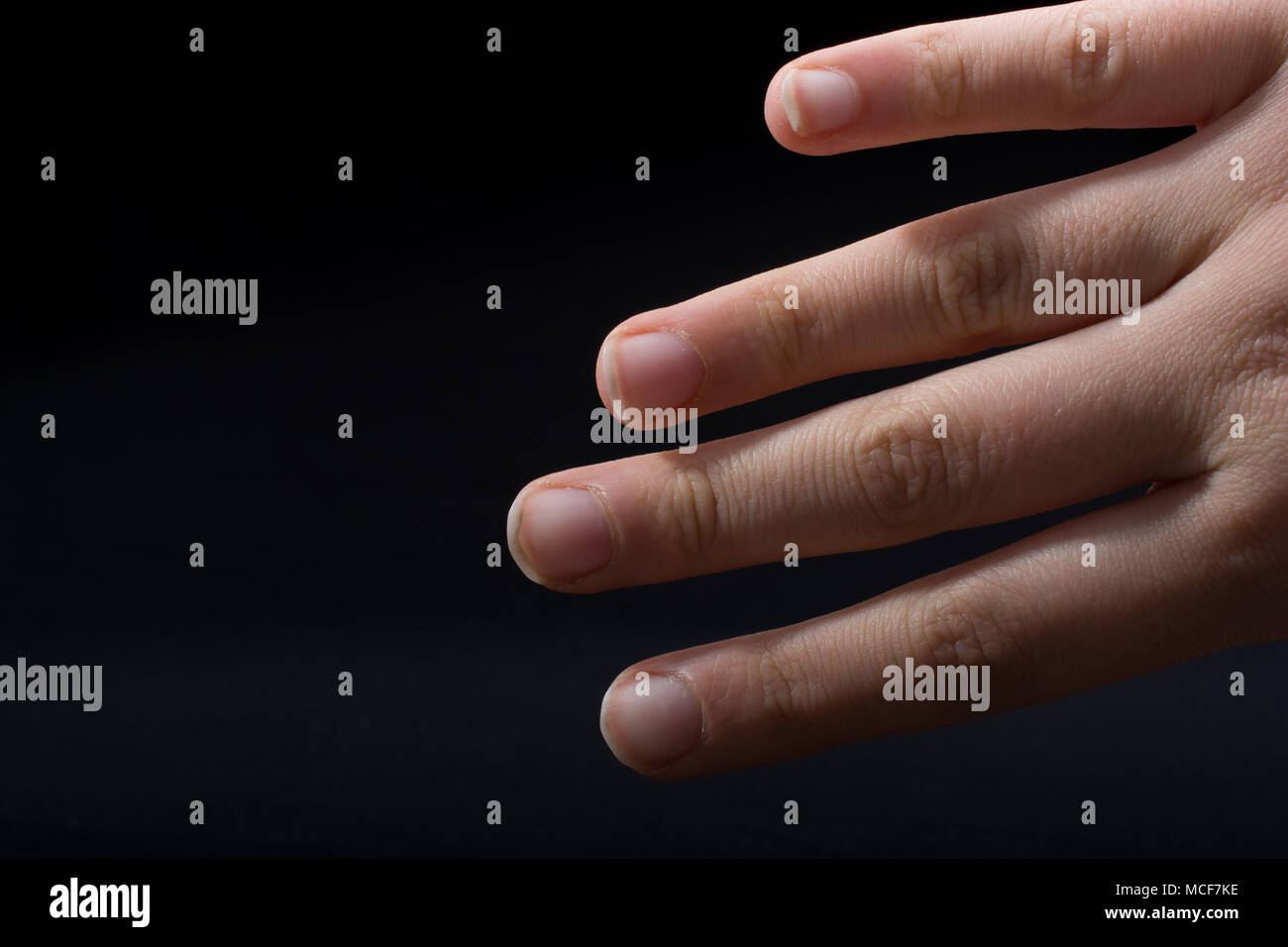 Four fingers of a child hand partly seen in black background Stock ...