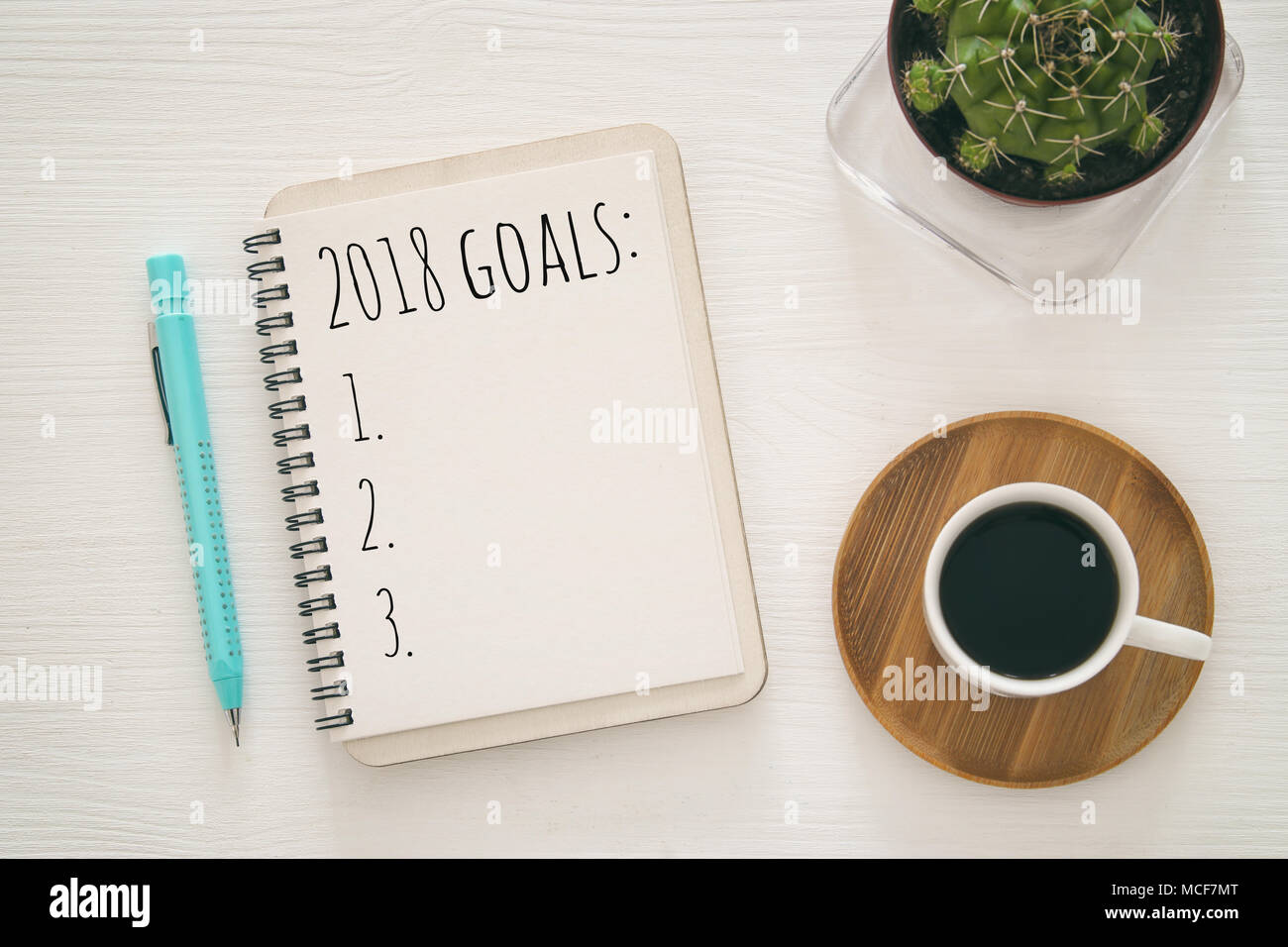 Top view 2018 goals list with notebook, cup of coffee on white ...