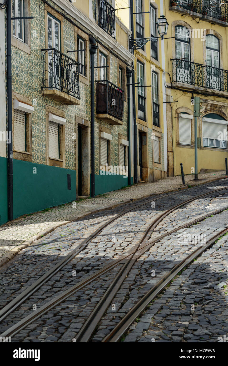 Profile of Lisbon high slope paved street with rail and tile facade ...