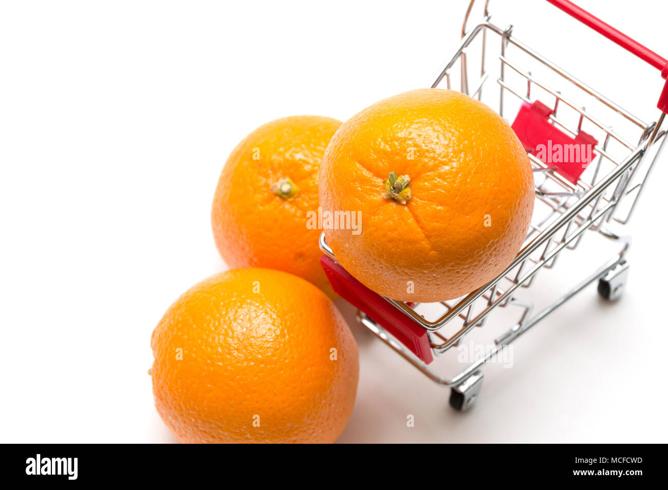 Orange and shopping cart on white background : economy concept Stock ...