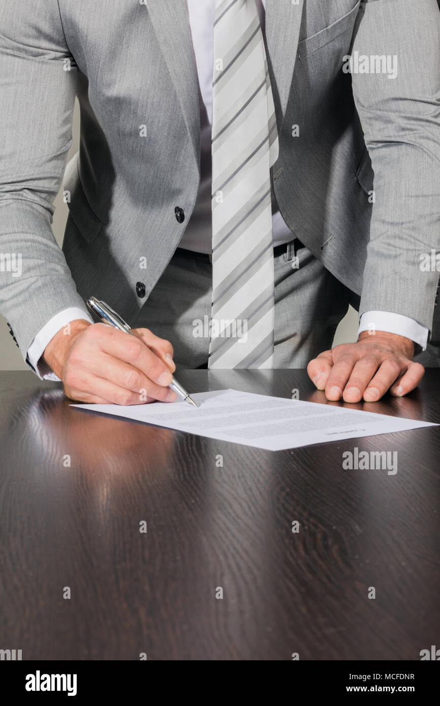 Standing holding signing paperwork document hi-res stock photography ...