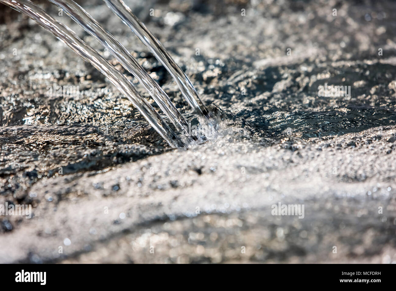 Jet of blue clear water with bubbles Stock Photo - Alamy