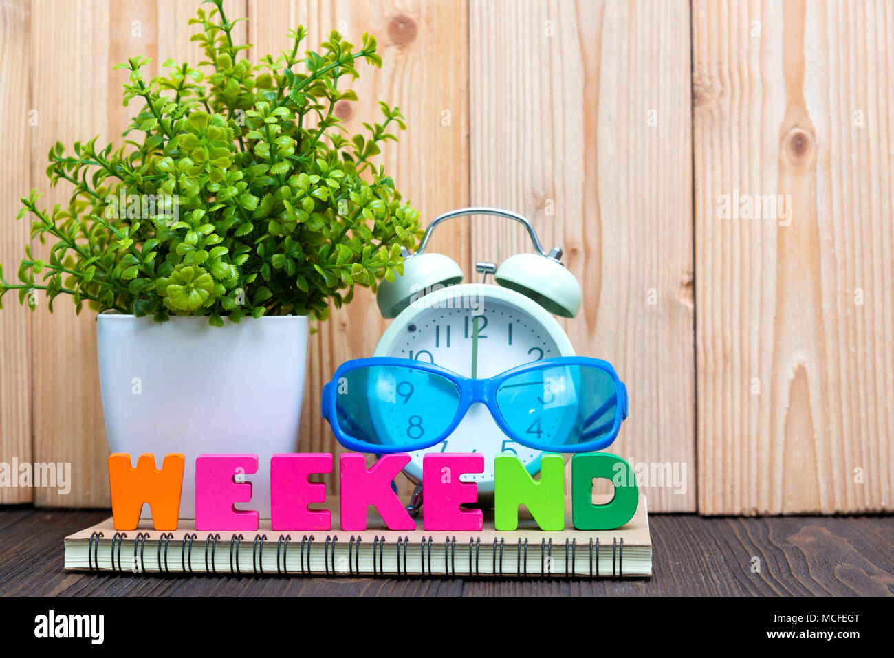 WEEKEND letters text and notebook paper, alarm clock and little ...