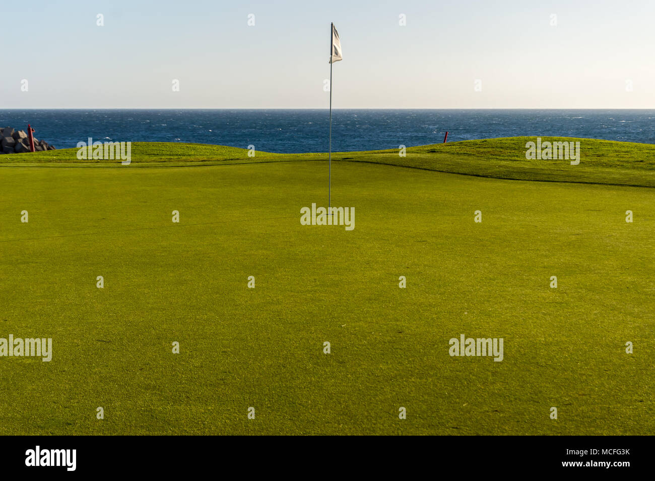 Green golf with flag and hole facing Atlantico ocean in Santa Cruz de ...