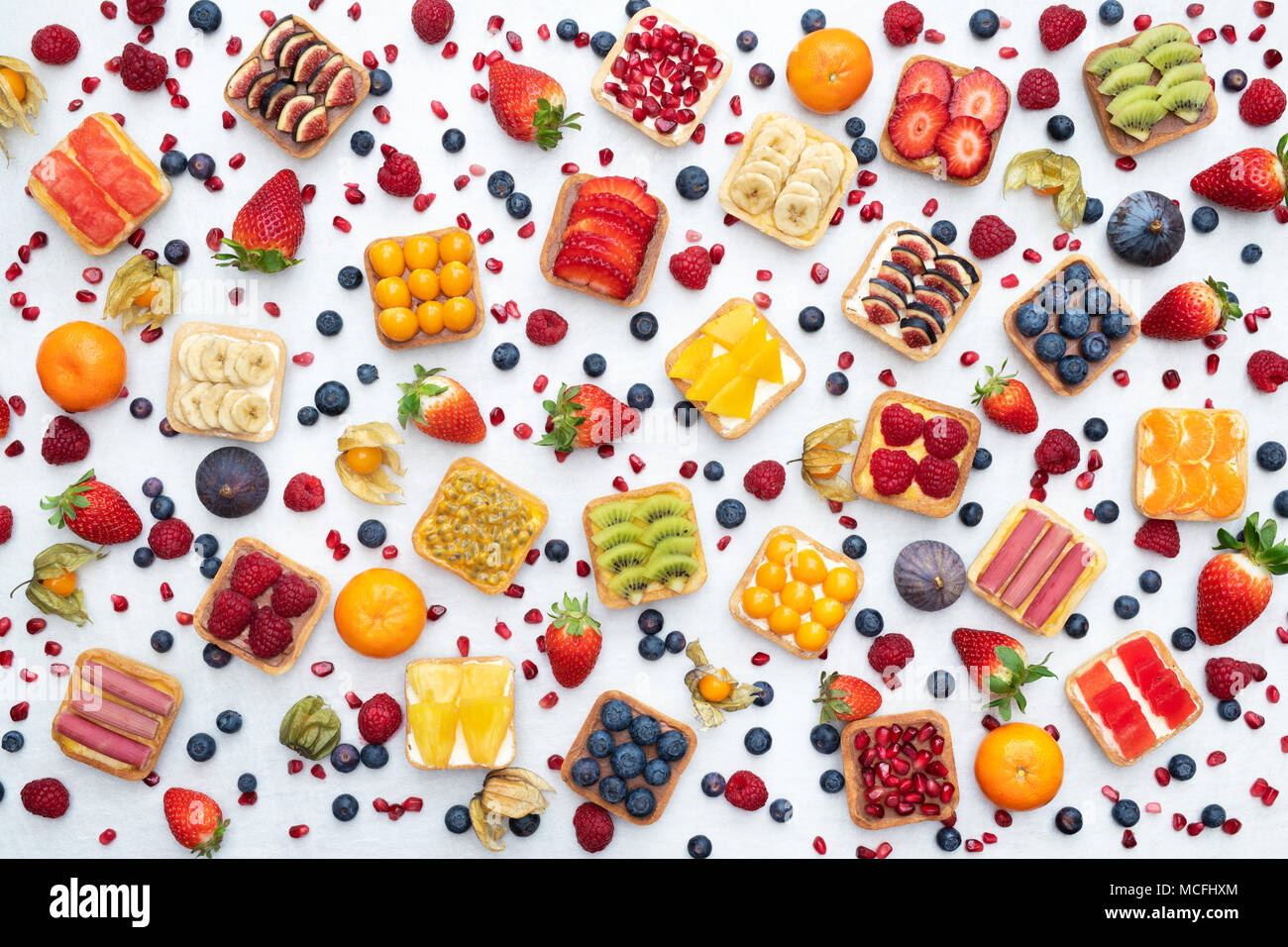 Colourful square fruit tarts on a white background Stock Photo - Alamy