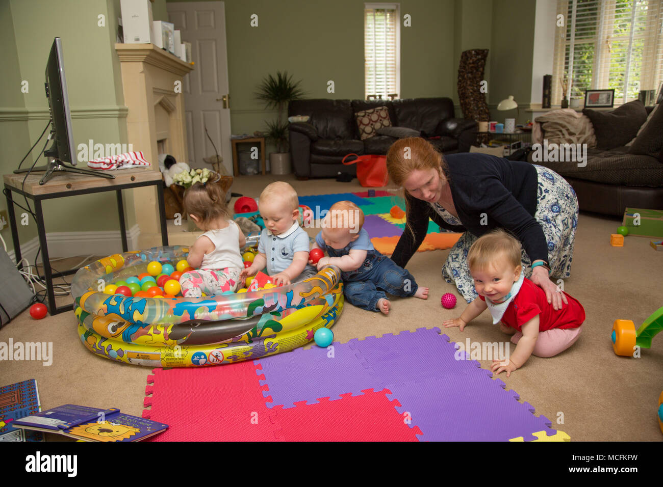 A childminder looking after babies in her home, UK Stock Photo - Alamy