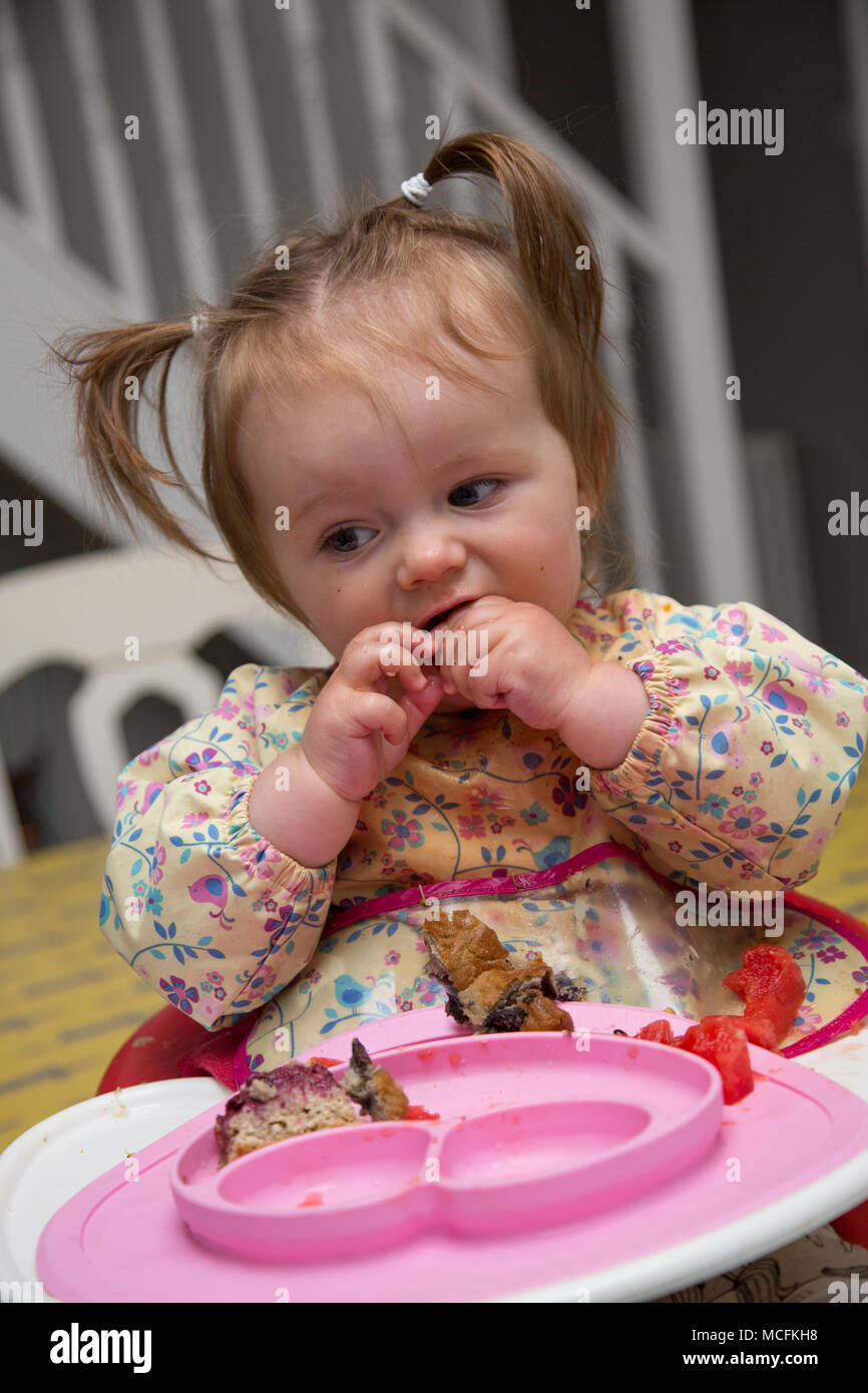 Baby being weaned in a highchair Stock Photo - Alamy