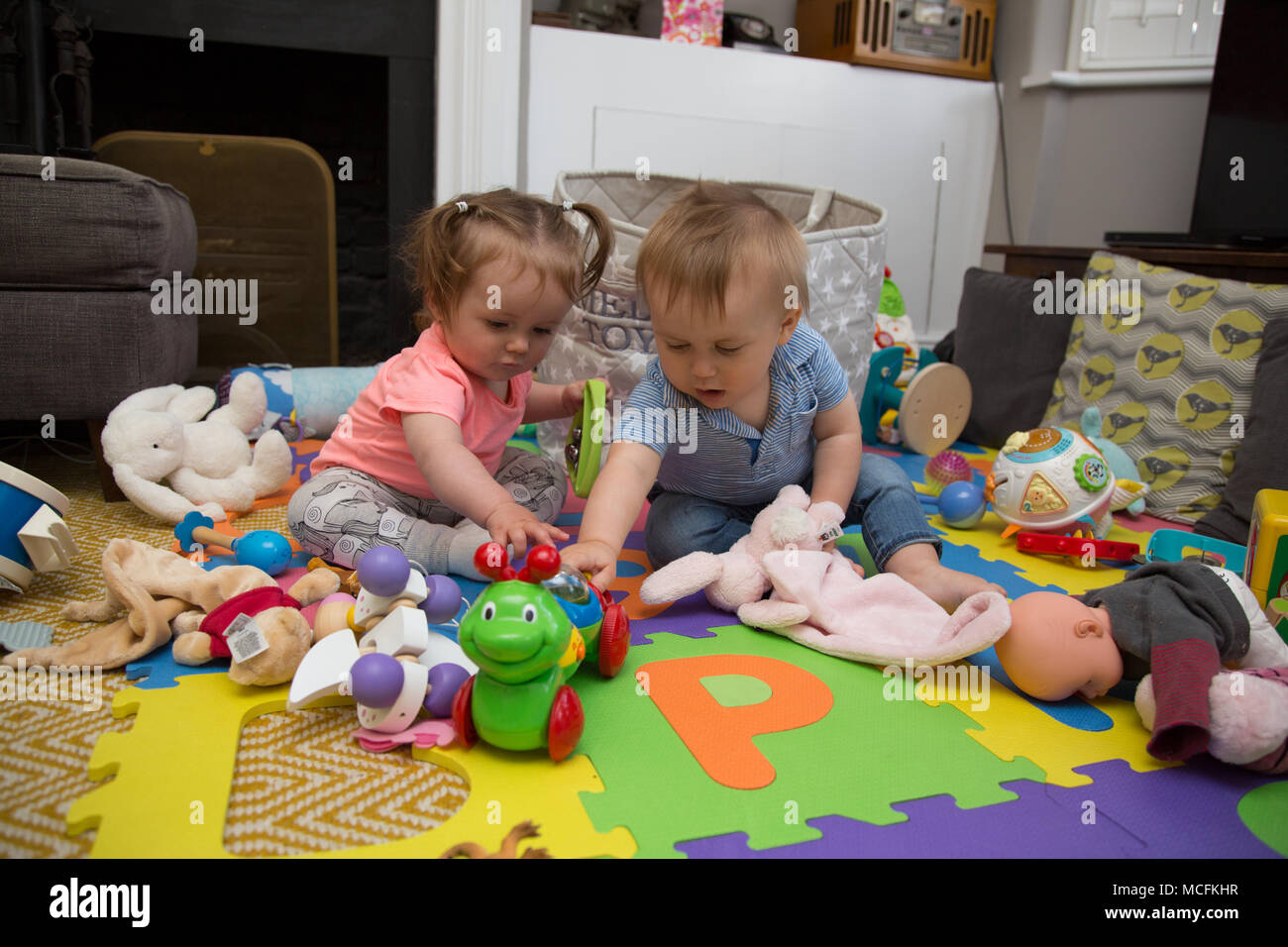 Babies playing with their toys Stock Photo - Alamy