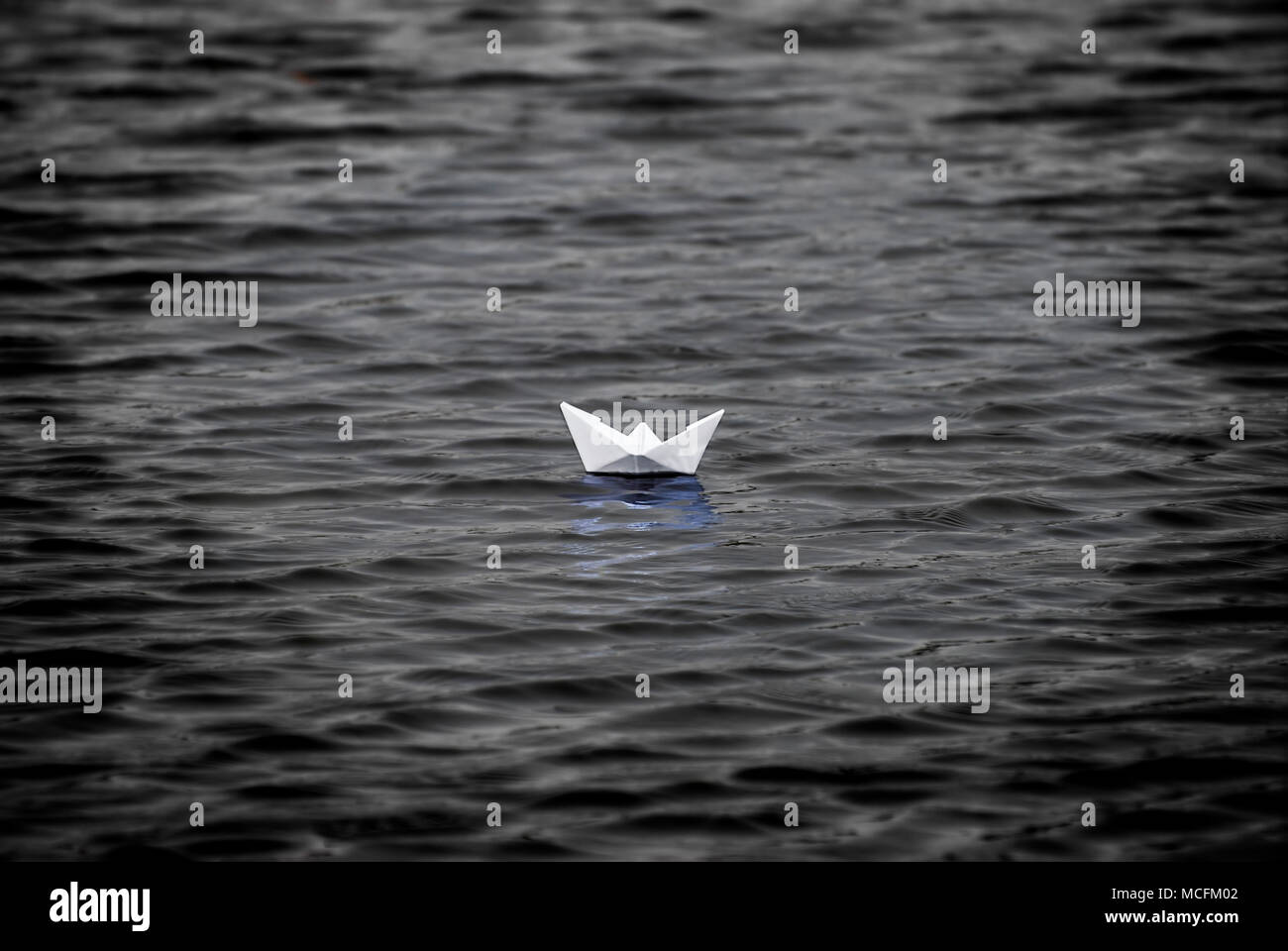 Boat made of paper floating on the dark water Stock Photo - Alamy