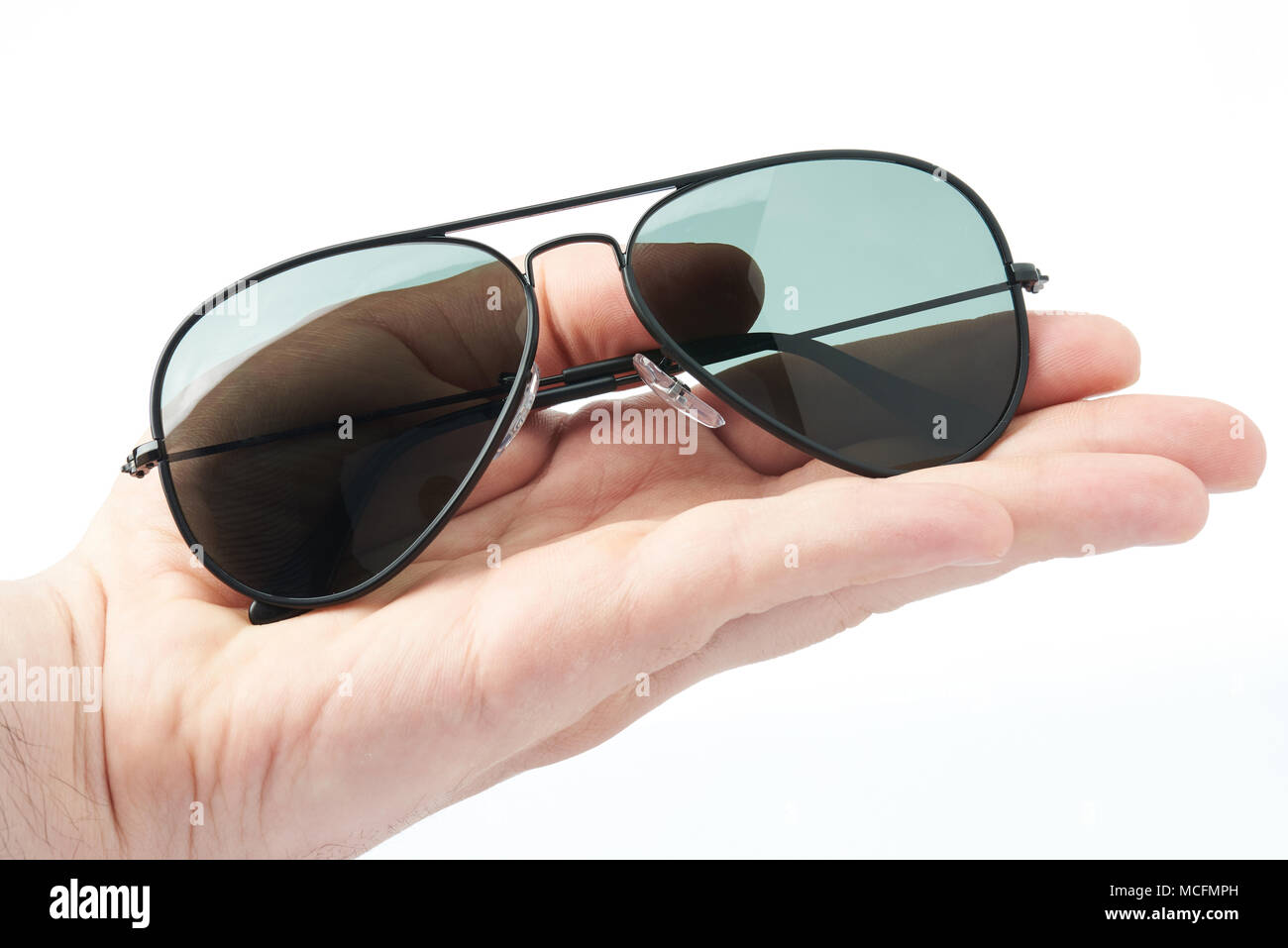 Hand hold polarized sunglasses close up isolated on white background ...