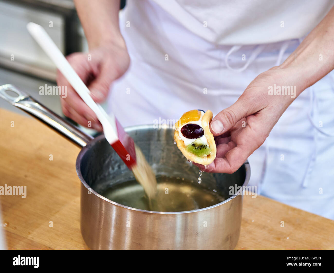 Cooking of cakes. Soaking with a brush with sweet syrup Stock Photo - Alamy