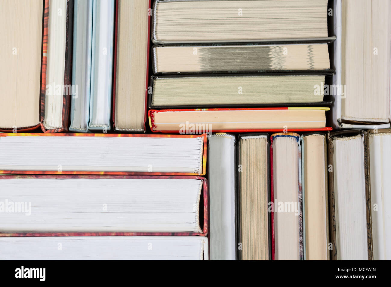 Pile of various books on bright wooden background. With copy space for ...