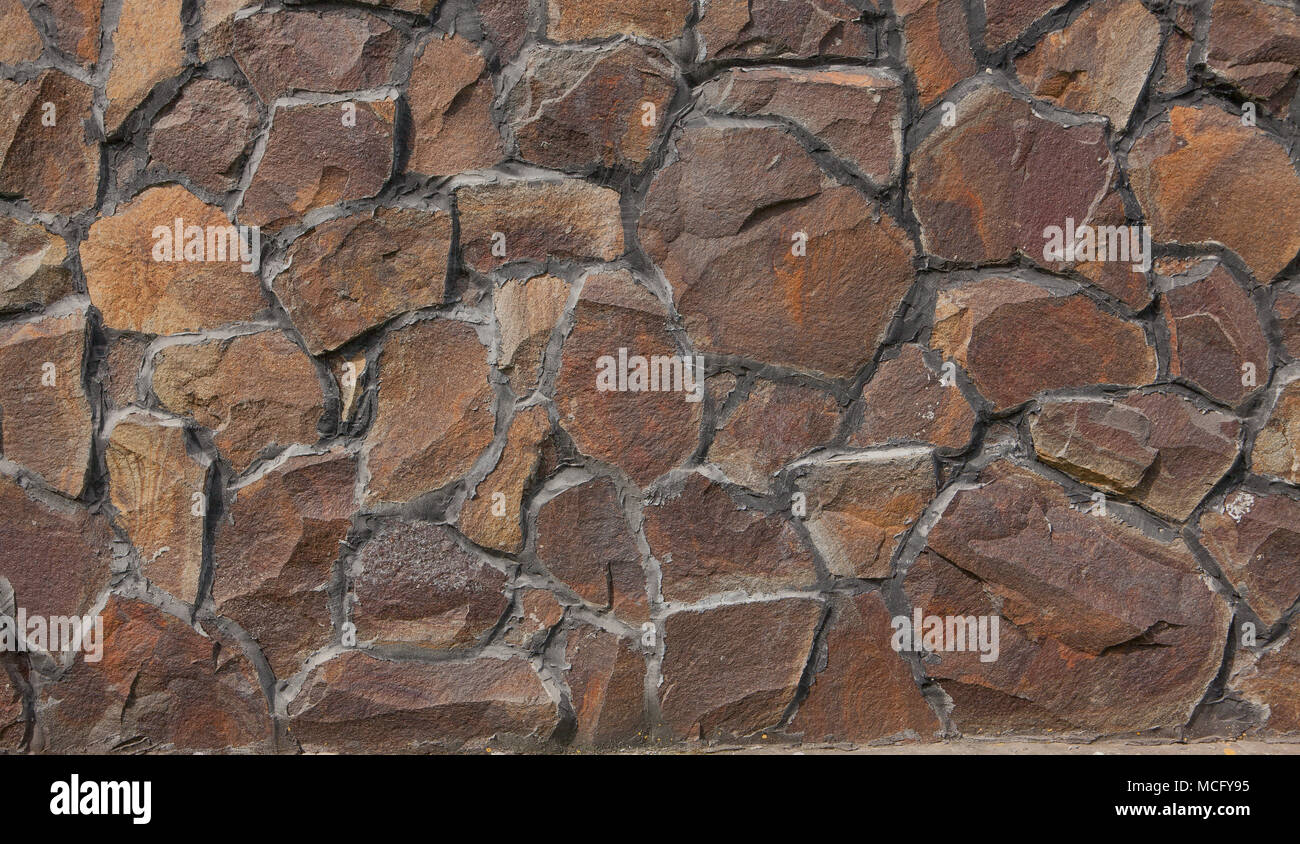 A wall of large rough stones, a stone fence. Beautiful natural stones ...