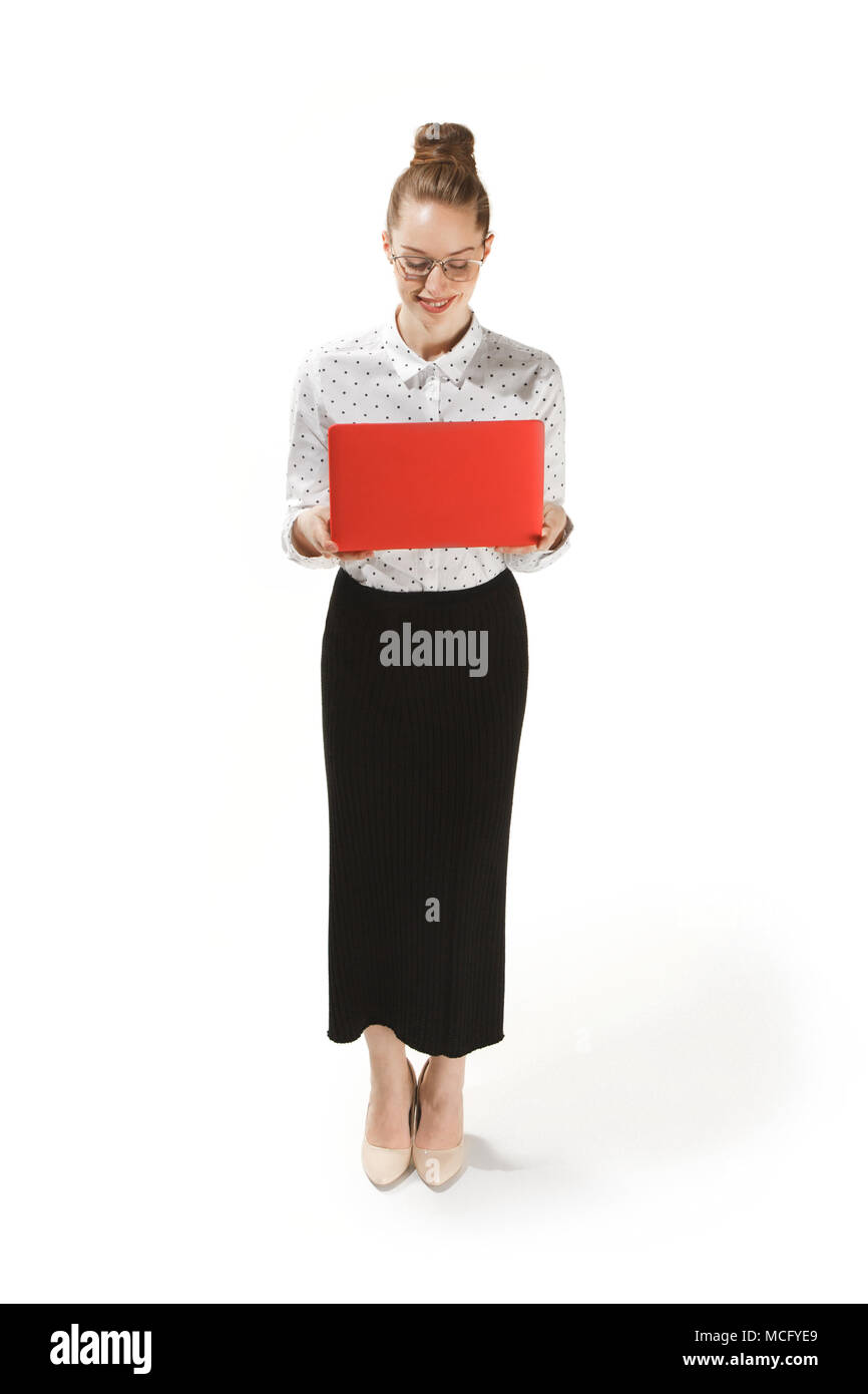 Full length portrait of a smiling female teacher holding a laptop ...