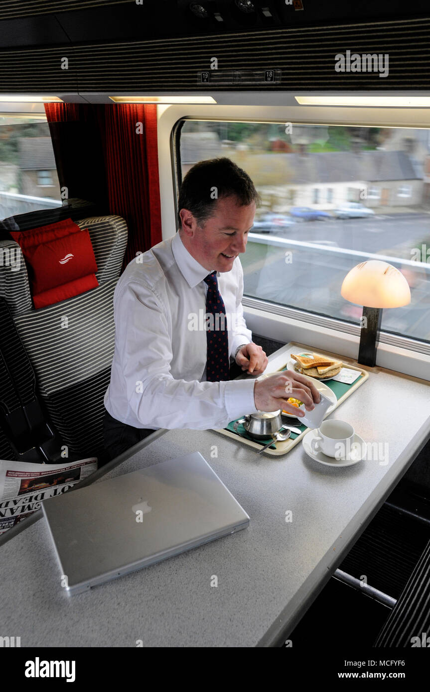 A businessman having breakfast in the 1st class compartment of an inter ...