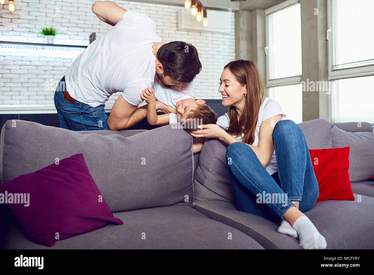 Happy family having fun playing together on a couch Stock Photo - Alamy