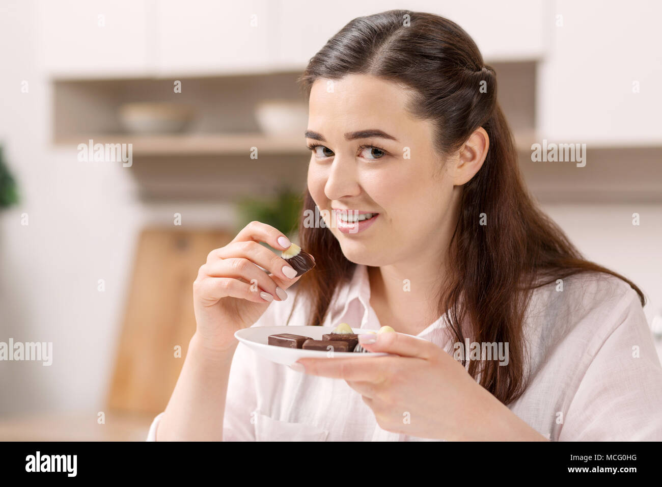 Jolly happy woman relishing candies Stock Photo - Alamy
