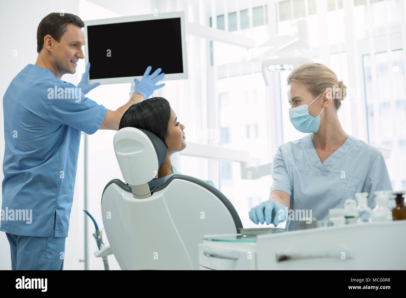Kind dentist looking at her patient Stock Photo - Alamy