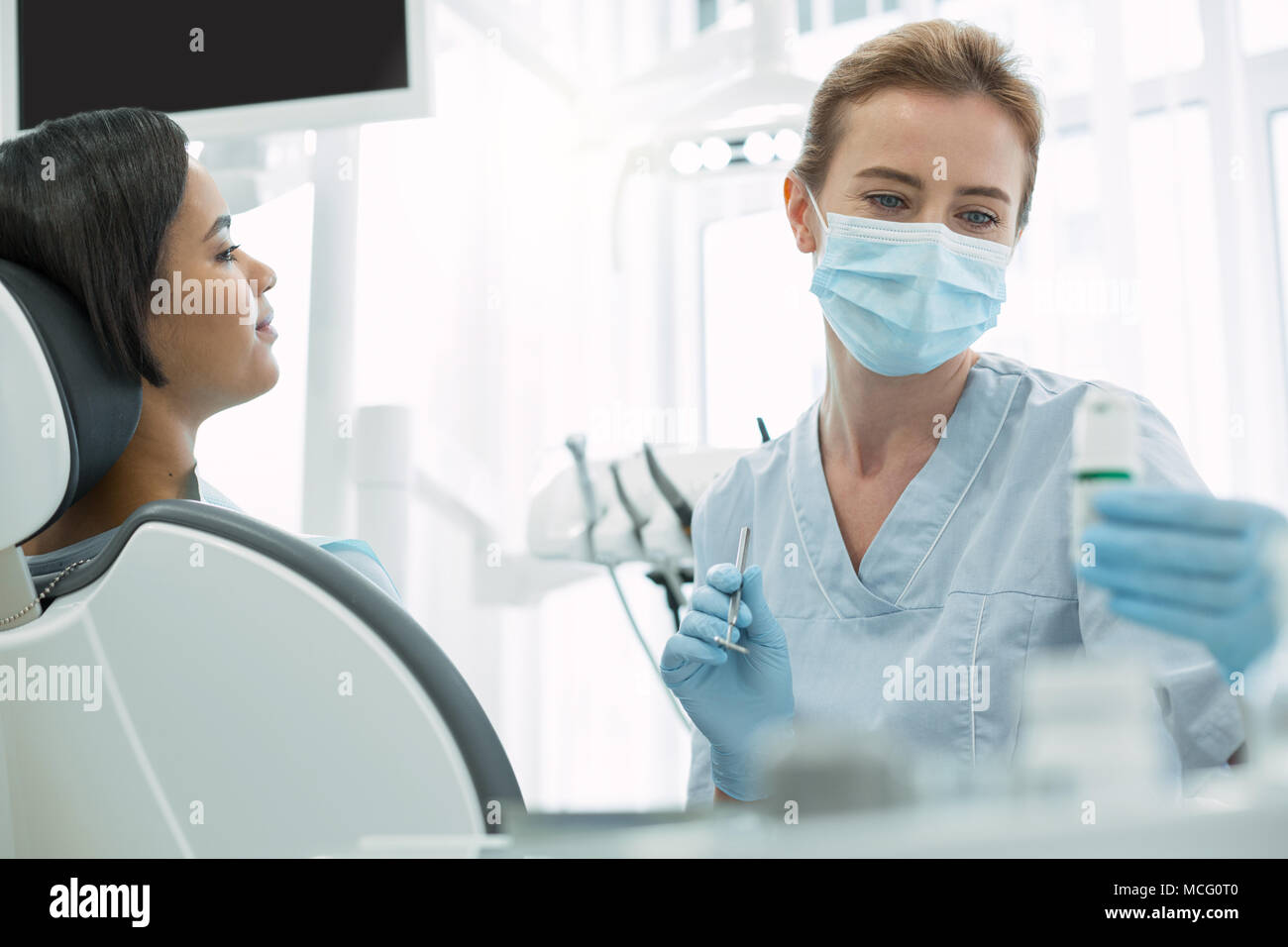 Serious dentist holding an instrument Stock Photo - Alamy