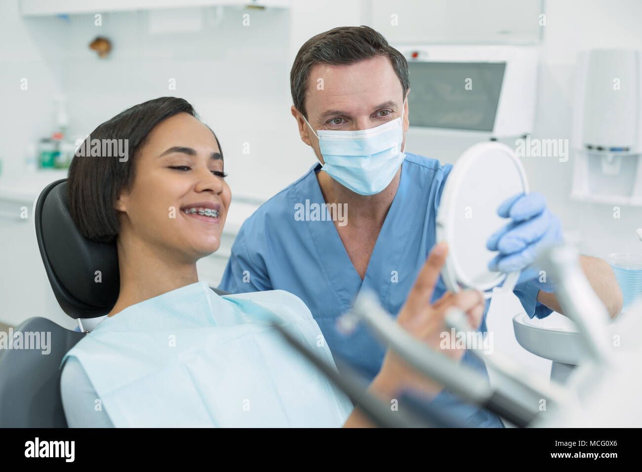 Happy patient looking in the mirror Stock Photo - Alamy