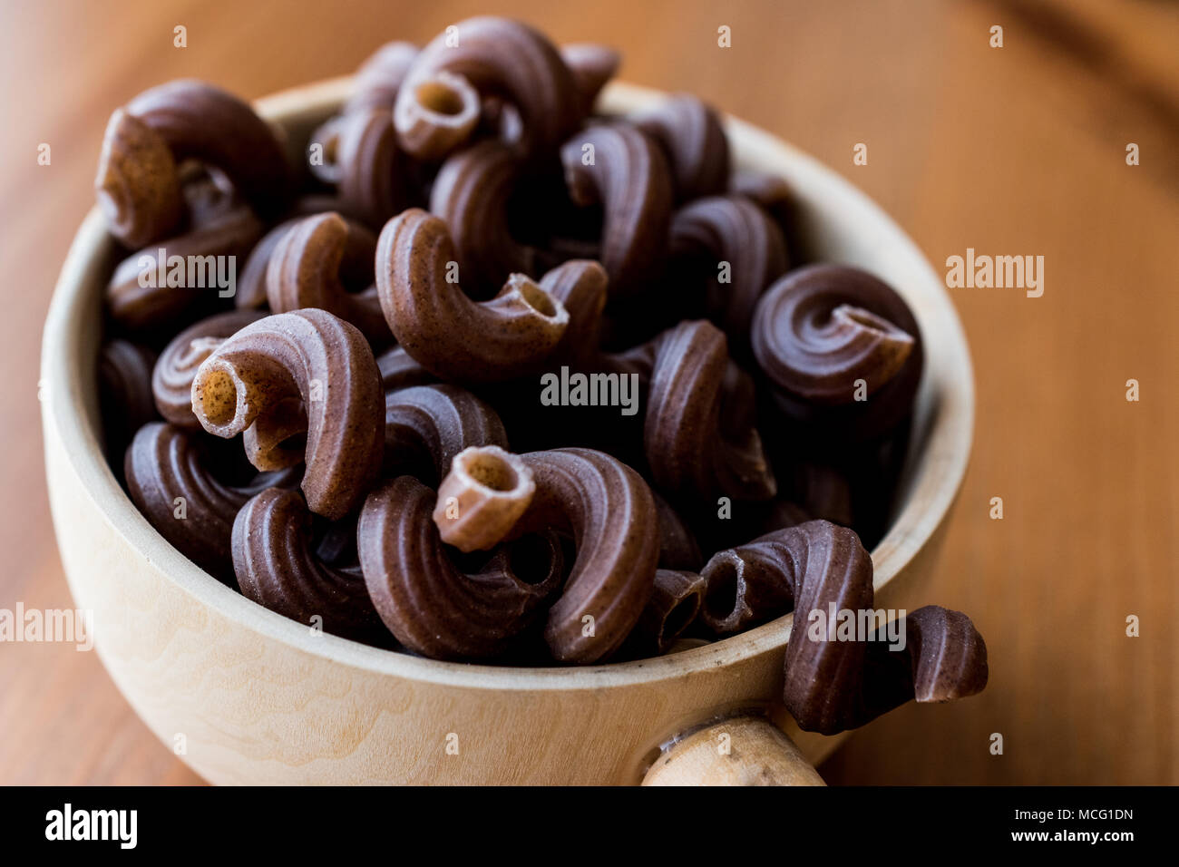 Raw Brown Pasta with Grape seeds in wooden ladle. Organic Food Stock ...