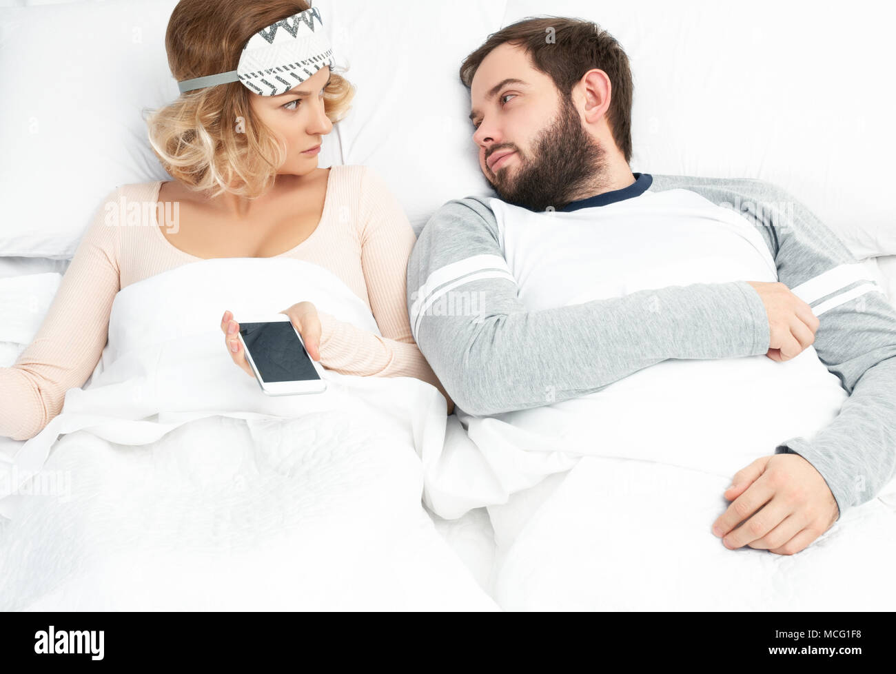 Couple sleep together in bed. Woman using her smart phone in bed Stock ...