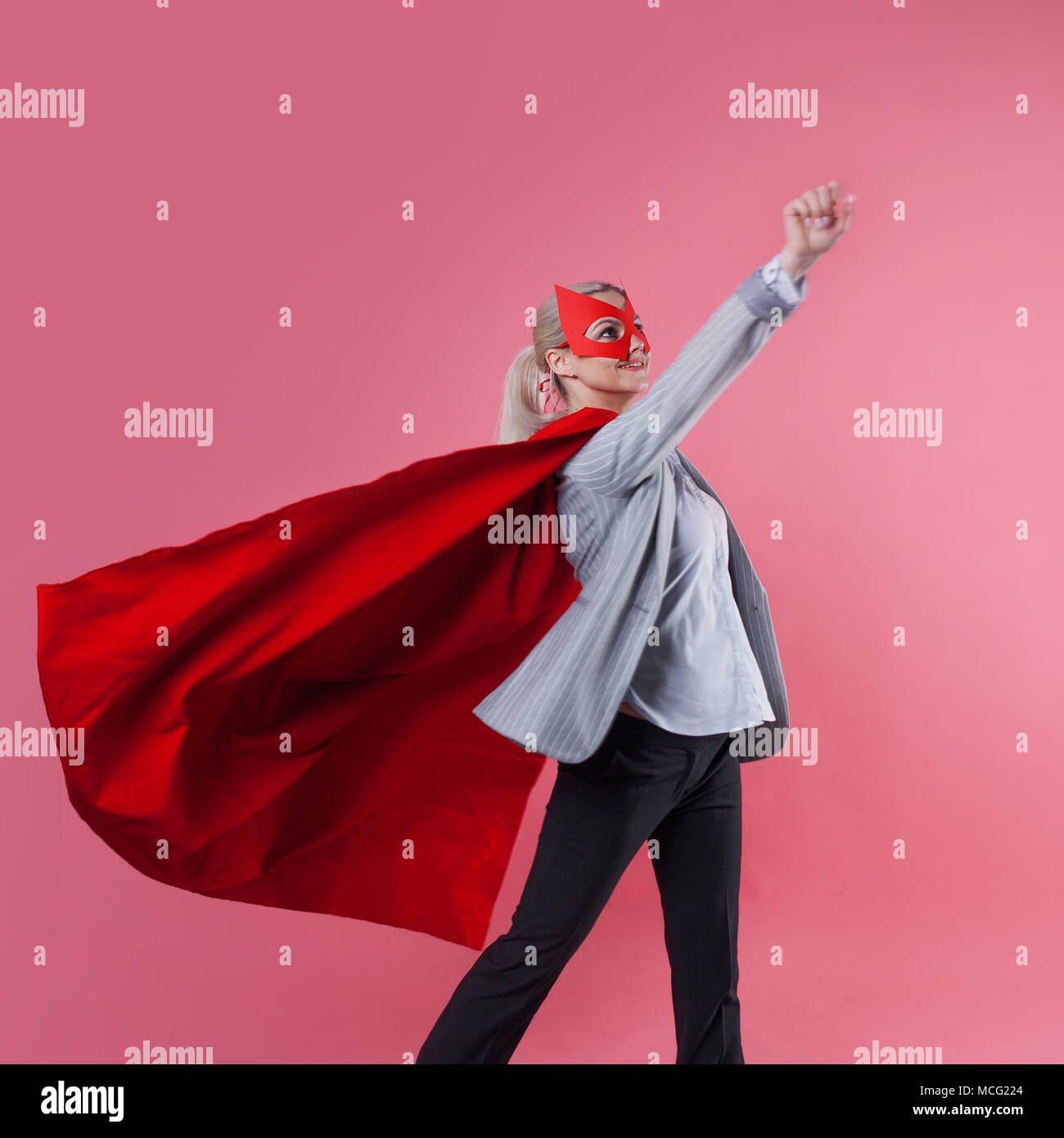 Young attractive woman superhero. Girl in a business suit and a mask ...