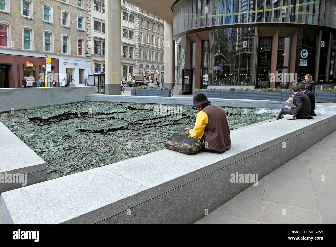 Woman sitting by "Forgotten Streams" sculpture by artist Cristina ...