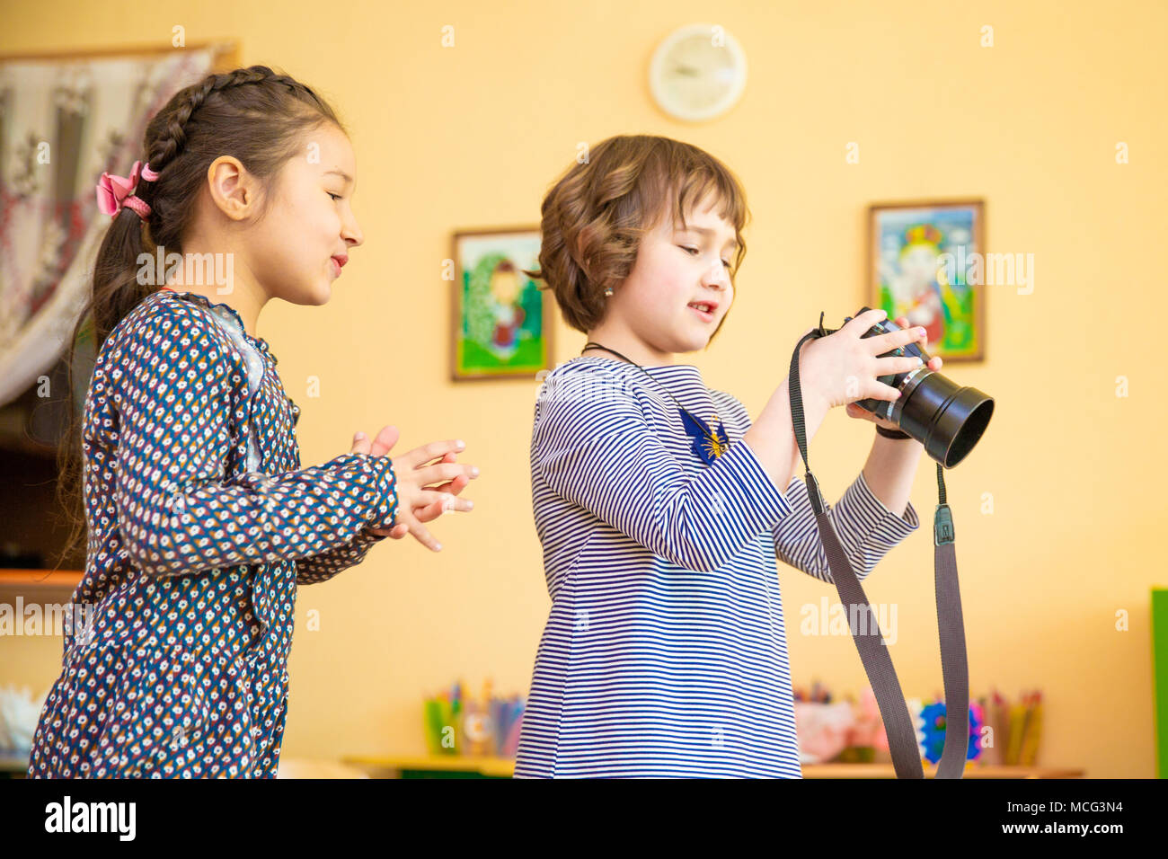 two little girls learning how to use photo camera Stock Photo - Alamy