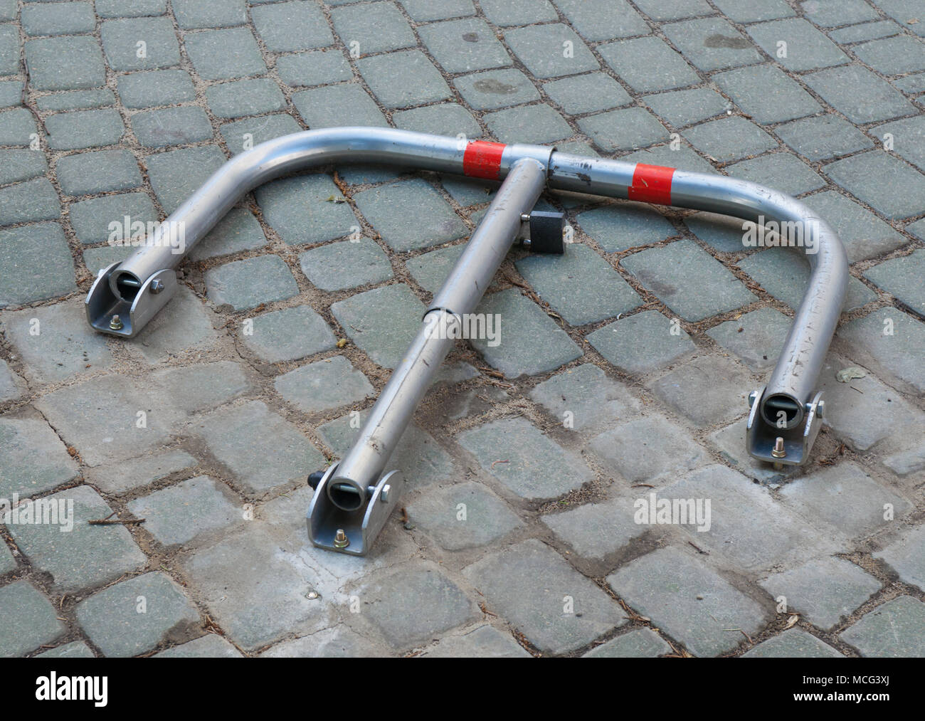 Folded parking barrier on a cobblestone pavement Stock Photo - Alamy