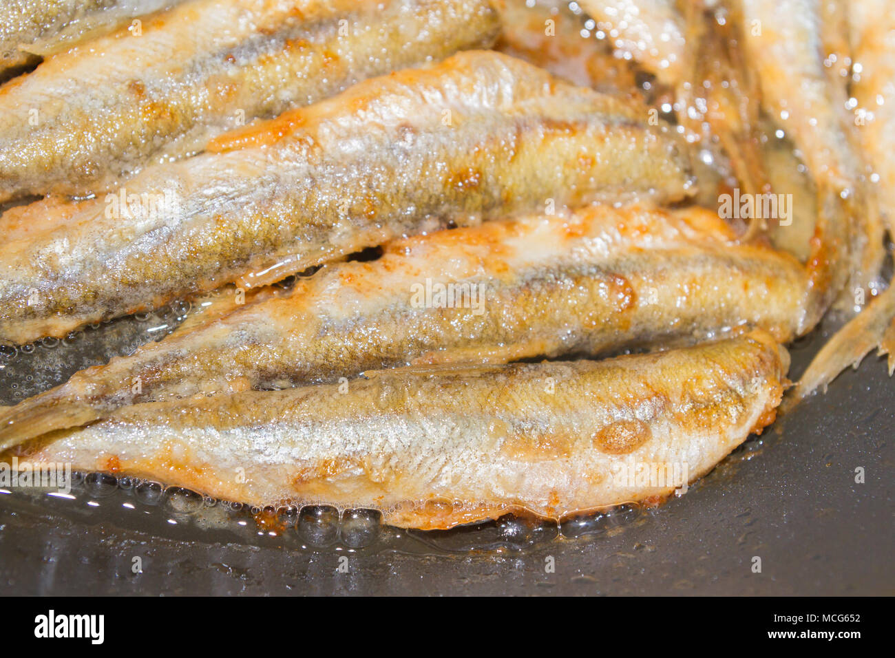 Cooking fried fish smelt rolled in flour Stock Photo - Alamy