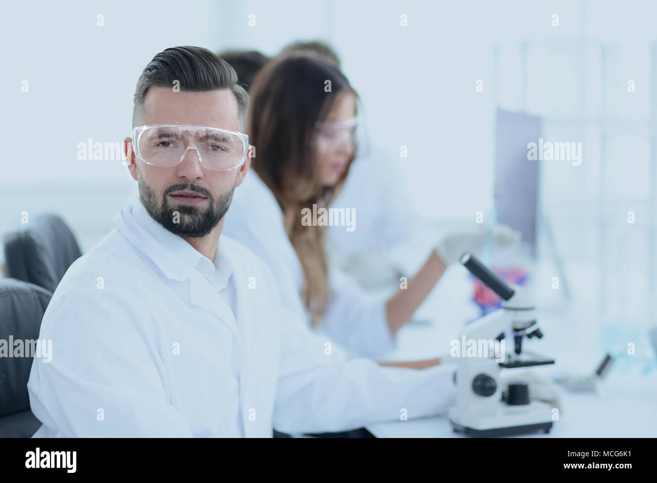 microbiologist and his colleagues are sitting in a modern laboratory ...
