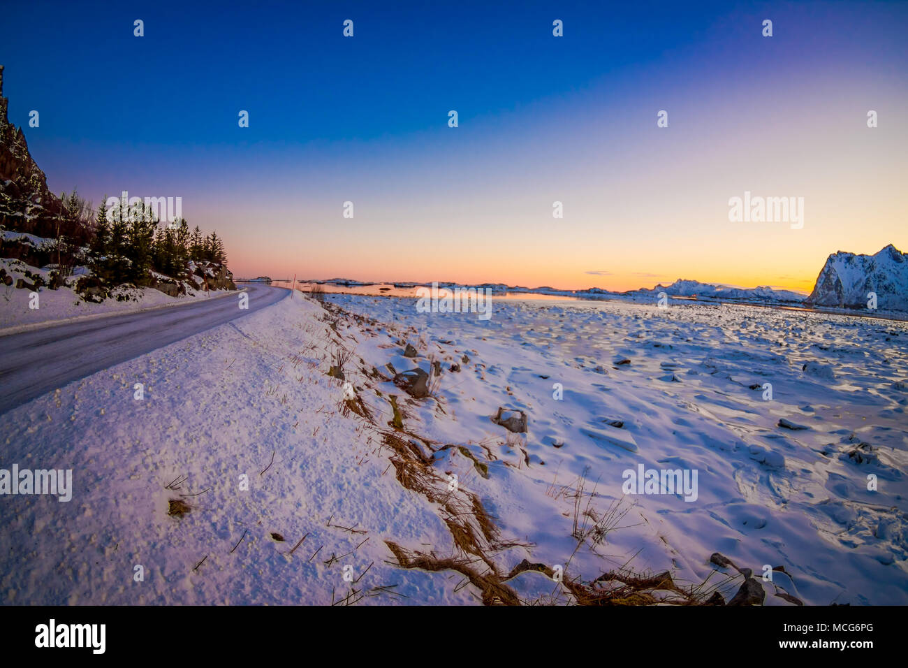Outdoor view of road covered with snow and seaside of frozen lake in a ...