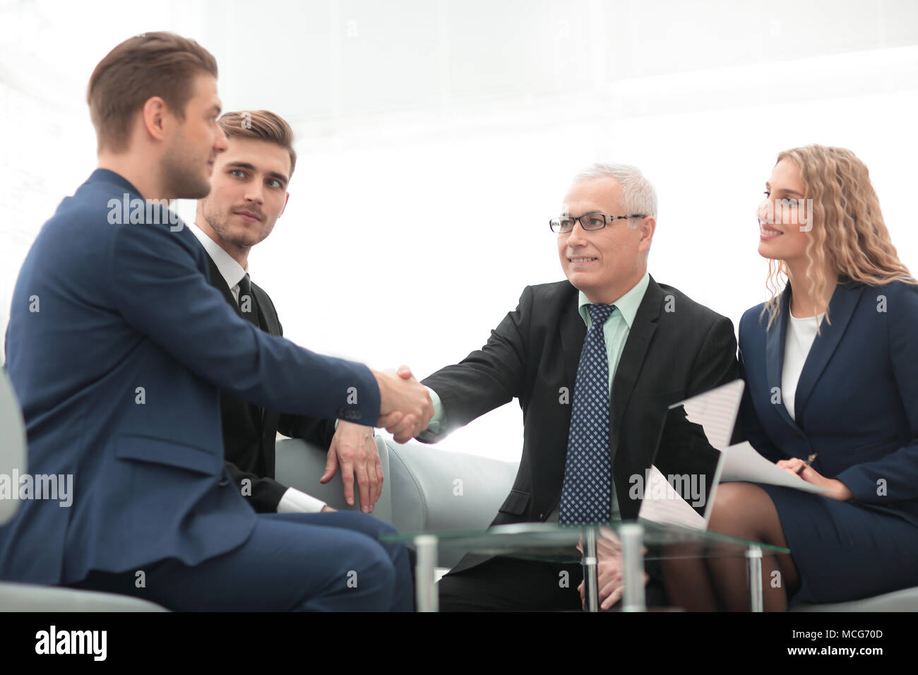 Partners concluding deal and shaking hands in the presence of team ...