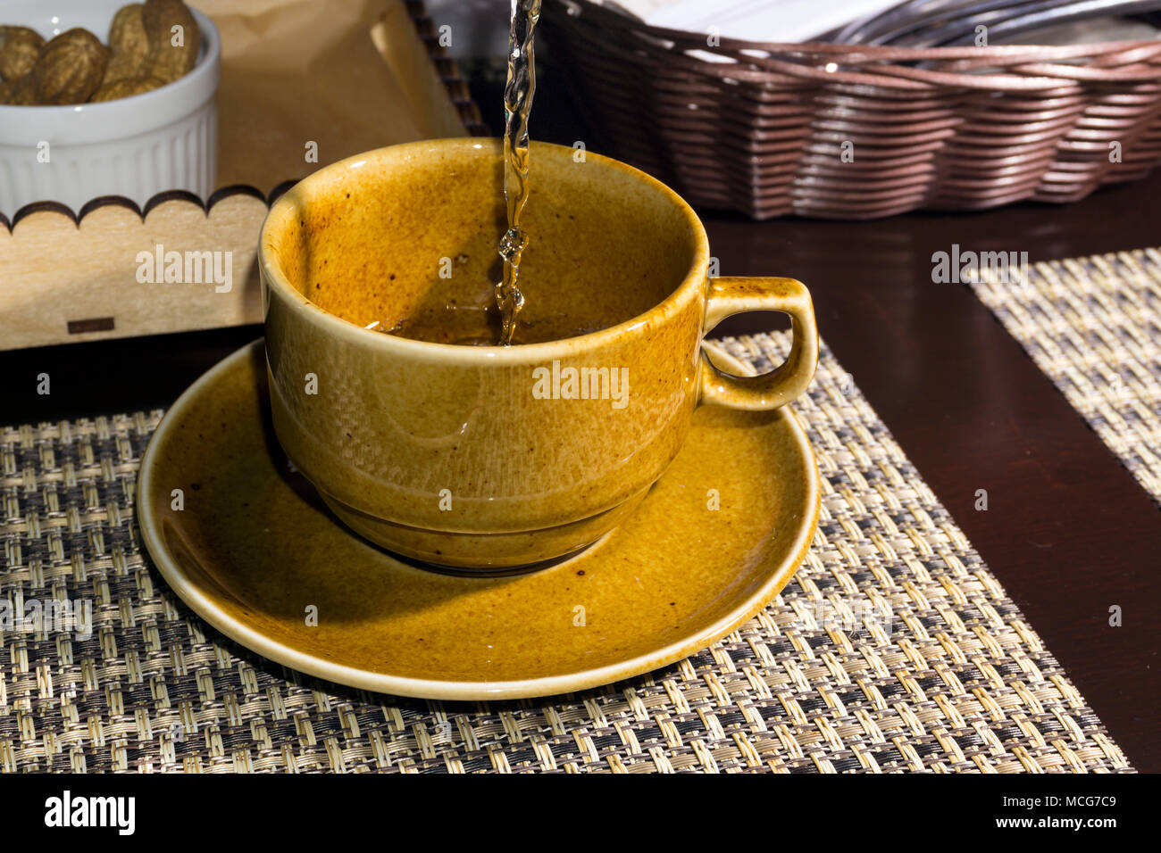 cup in yellow spotted glaze with green tea closeup on blurred ...