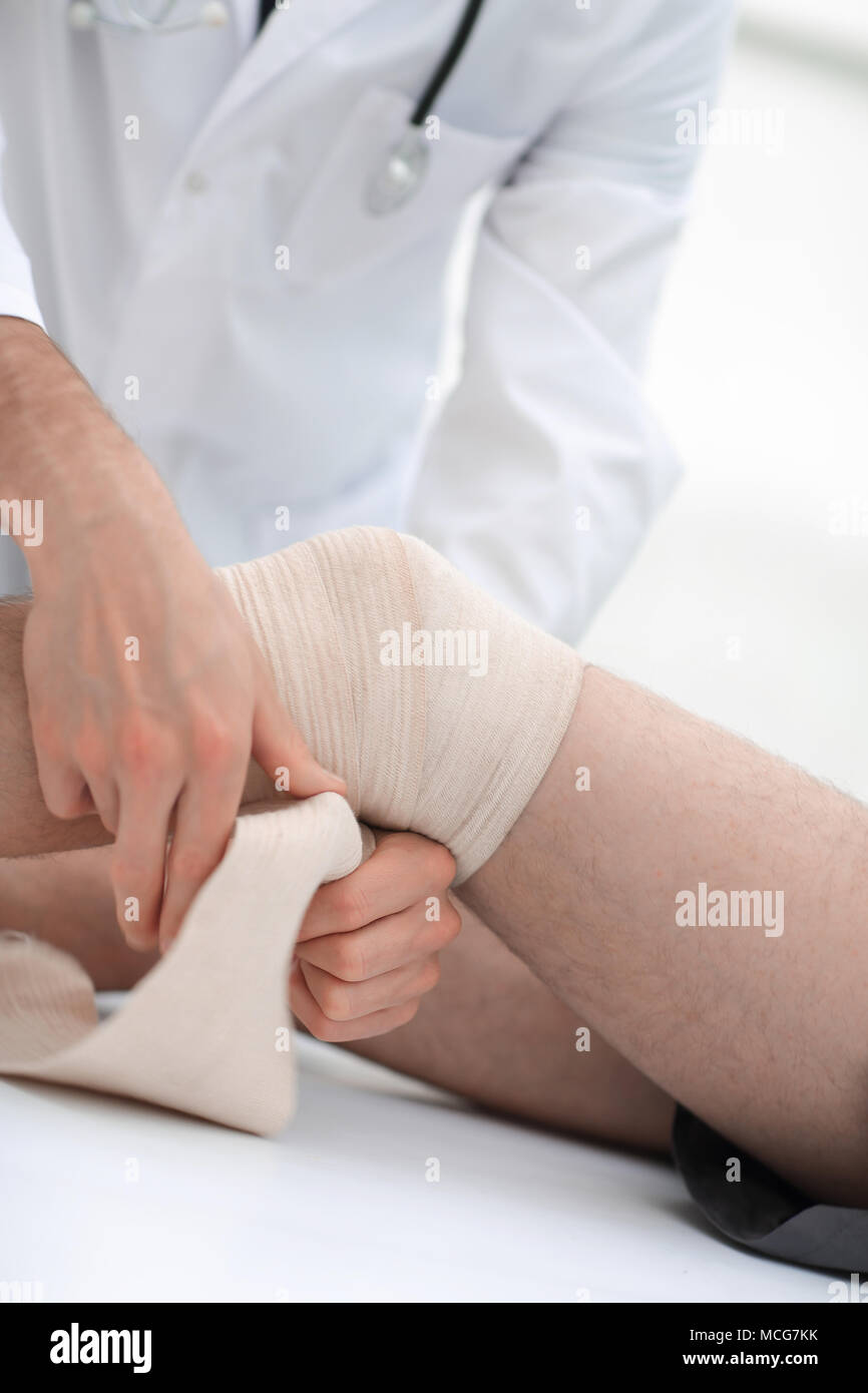 doctor bandaging patient knee Stock Photo - Alamy