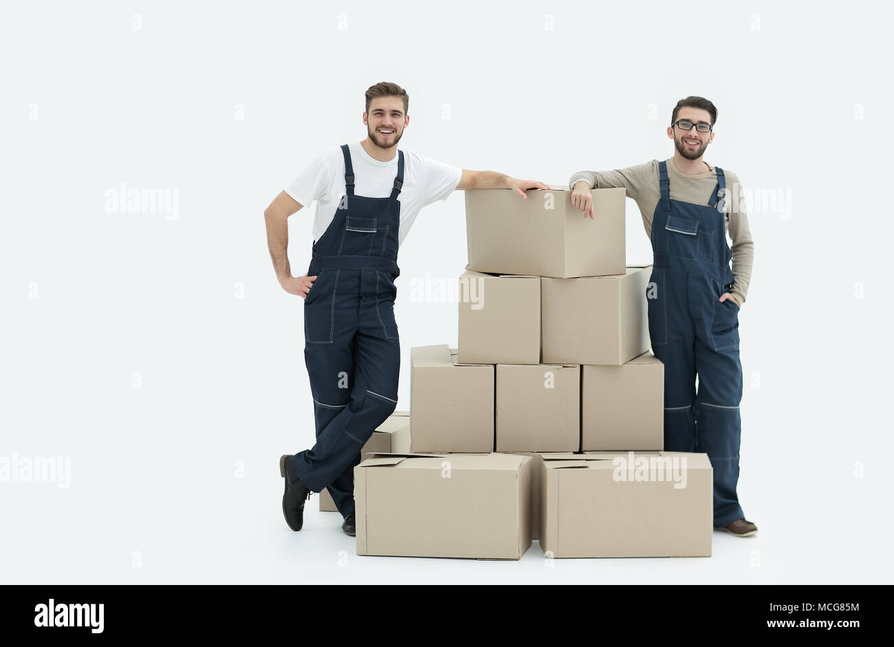 Young men carrying a box to the pile of boxes Stock Photo - Alamy