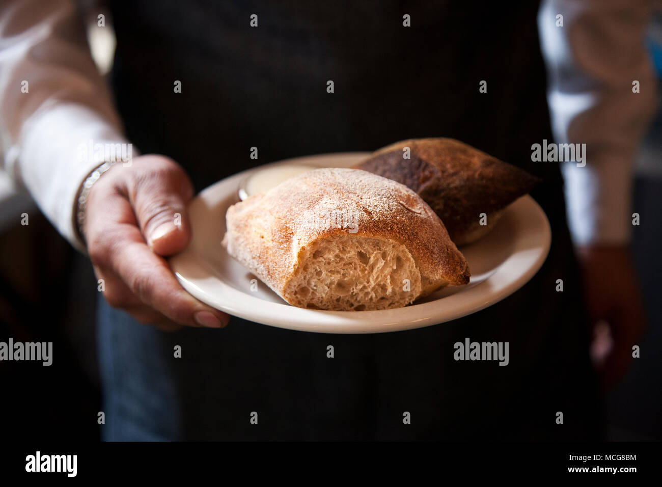 Bread rolls in the hand of a server at Havre 77. Mexico City Stock ...