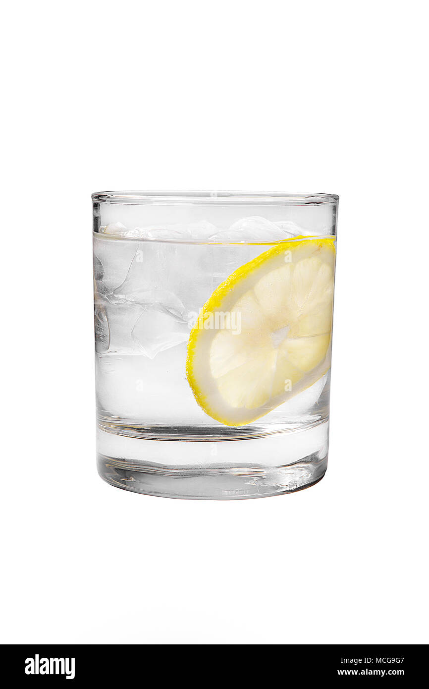 Transparent cocktail, refreshing water in a low glass with ice cubes and a round slice of lemon ...