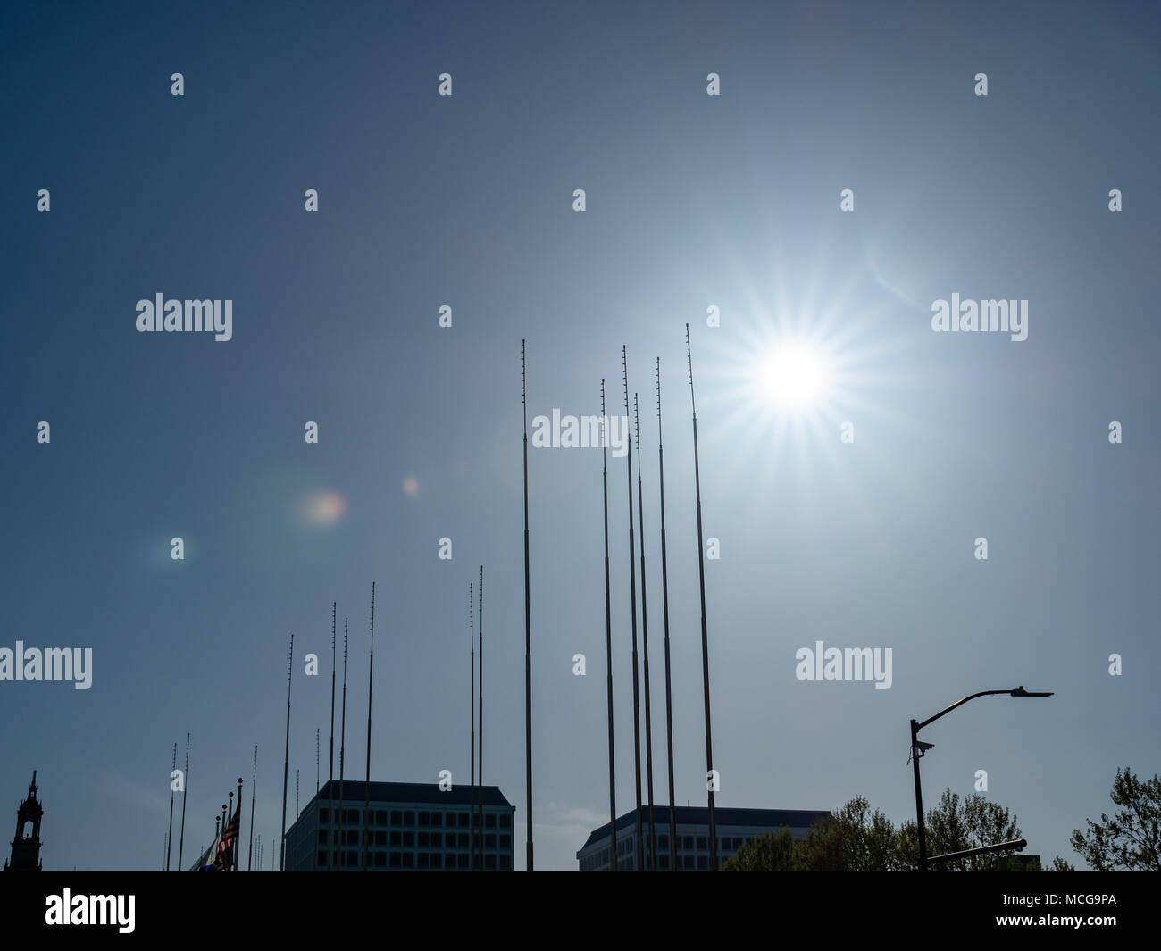 Sun and lens flare directly above park decorations on a cloudless day ...