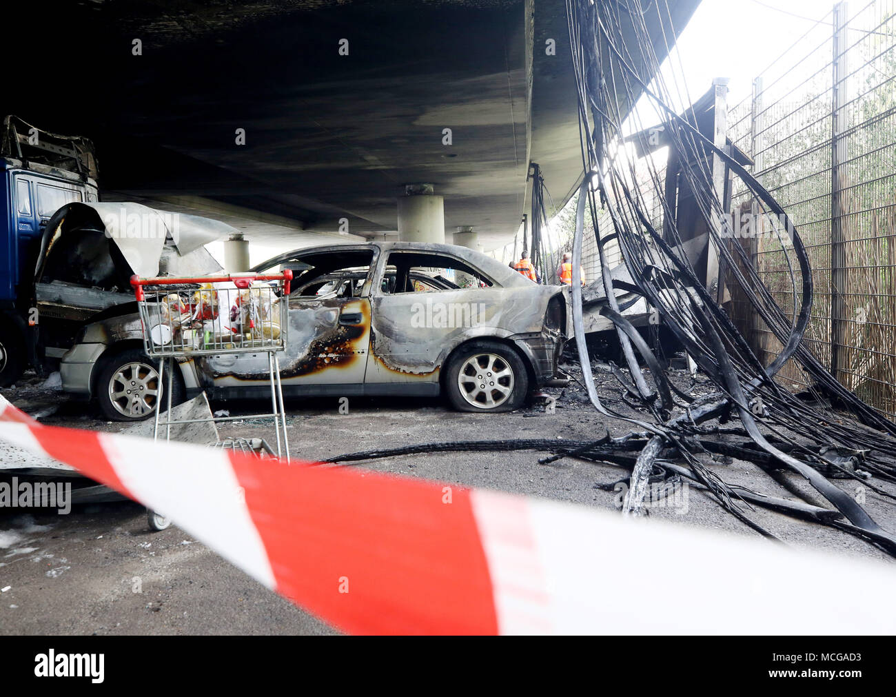 16 April 2018, Germany, Duisburg: Burned-out car wrecks under a bridge ...
