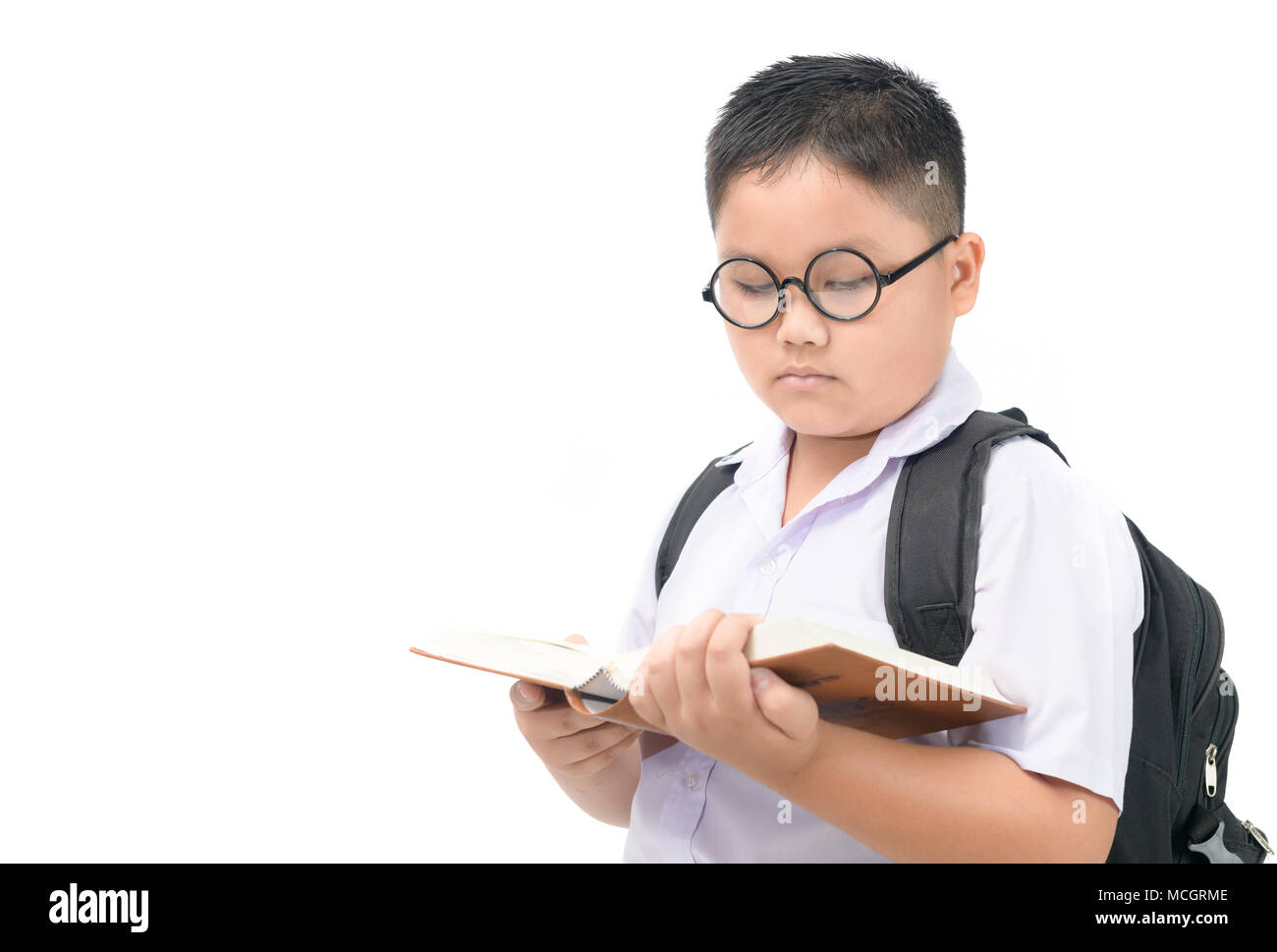 Asian boy student in uniform wear glasses reading book isolated on ...