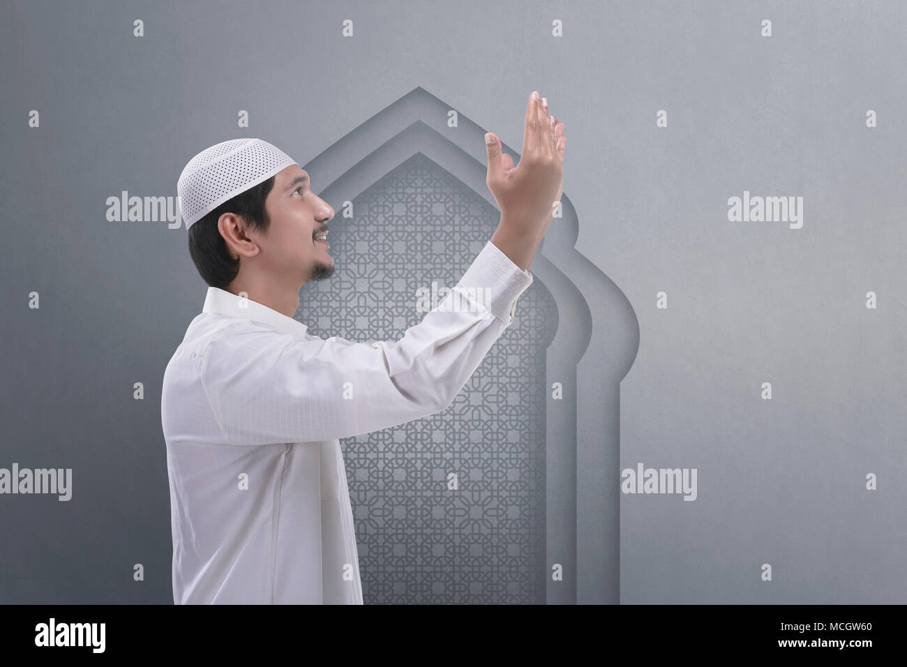 Handsome asian muslim man raising hand and pray on the mosque Stock ...