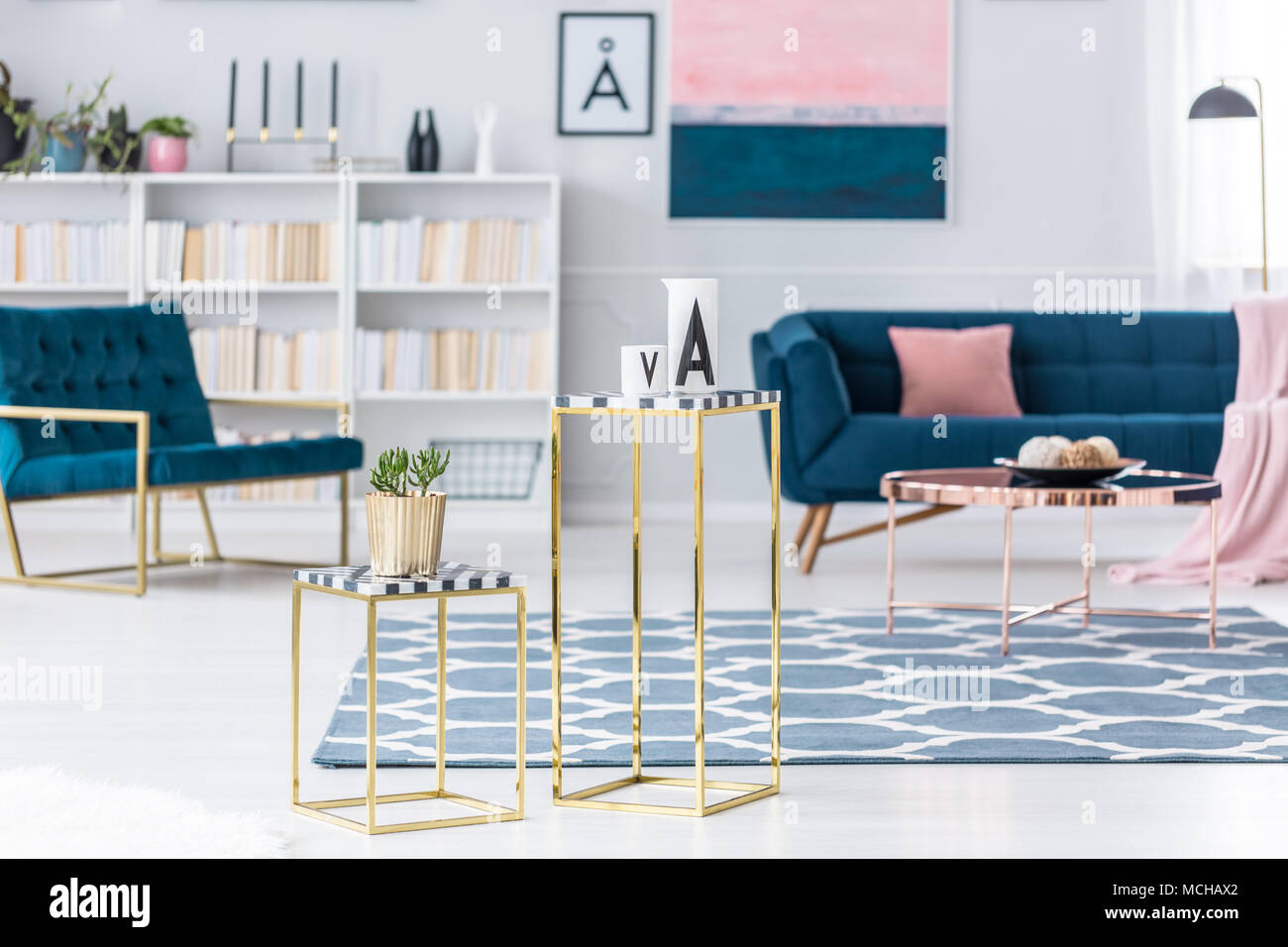 Creative, golden stools with plant and ceramic vessels set in a living ...