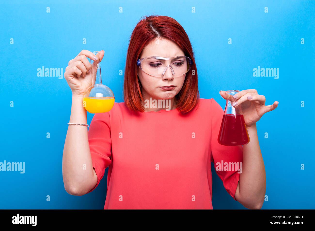 Confused chemist woman with two tubes with yellow and red liquid Stock ...