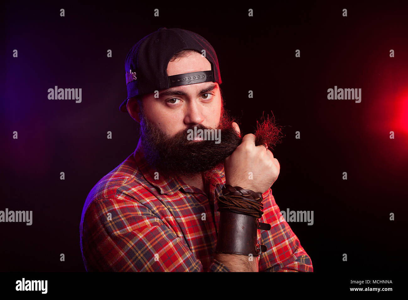 Angry bearded hipster man holding his beard in hands Stock Photo - Alamy