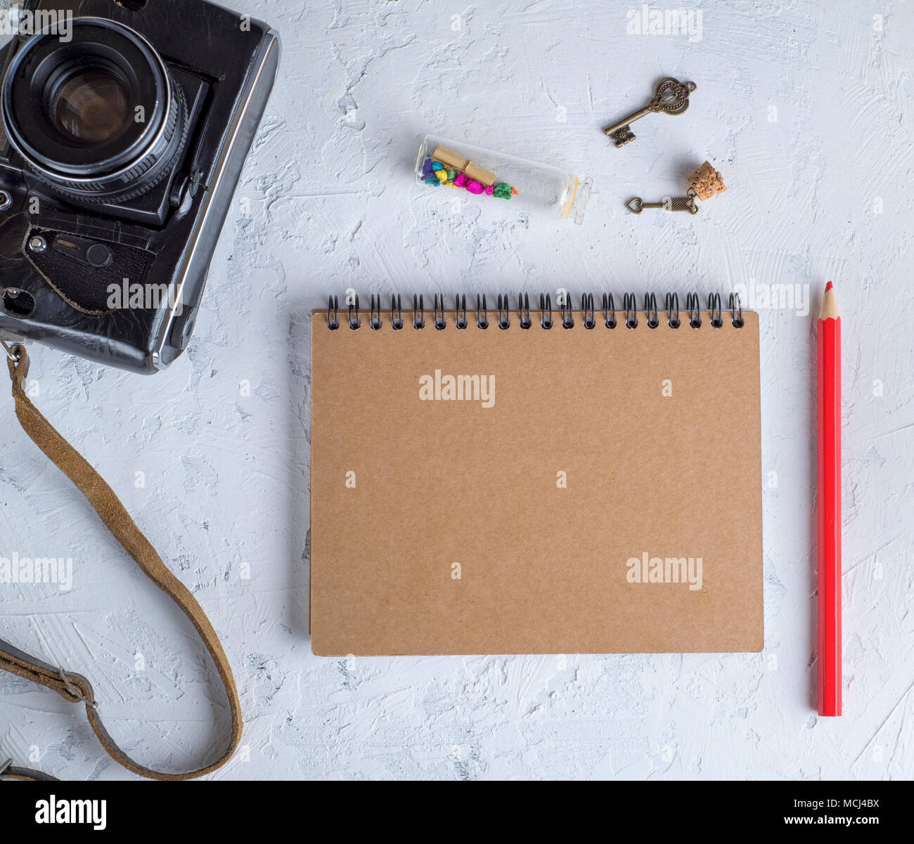 open blank notepad on an iron spring with brown sheets and a red wooden ...
