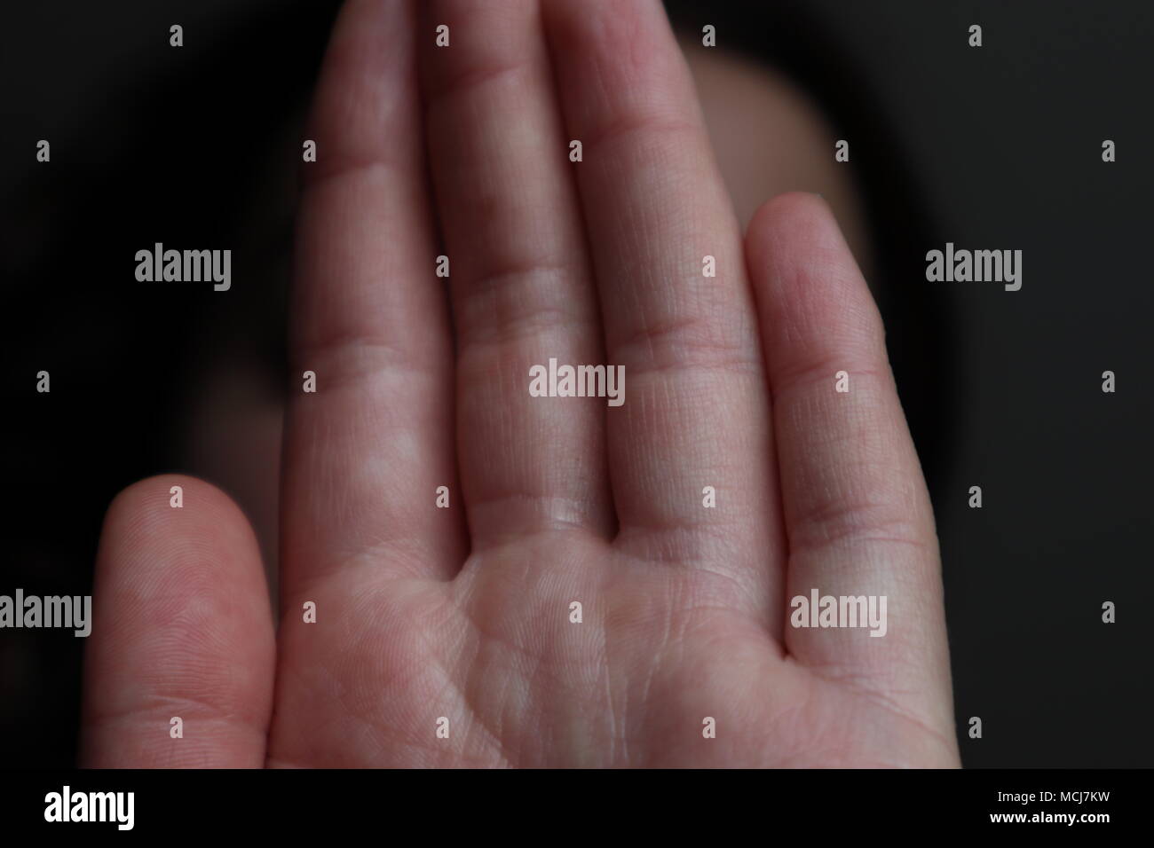 Young woman's hand covering her face Stock Photo - Alamy