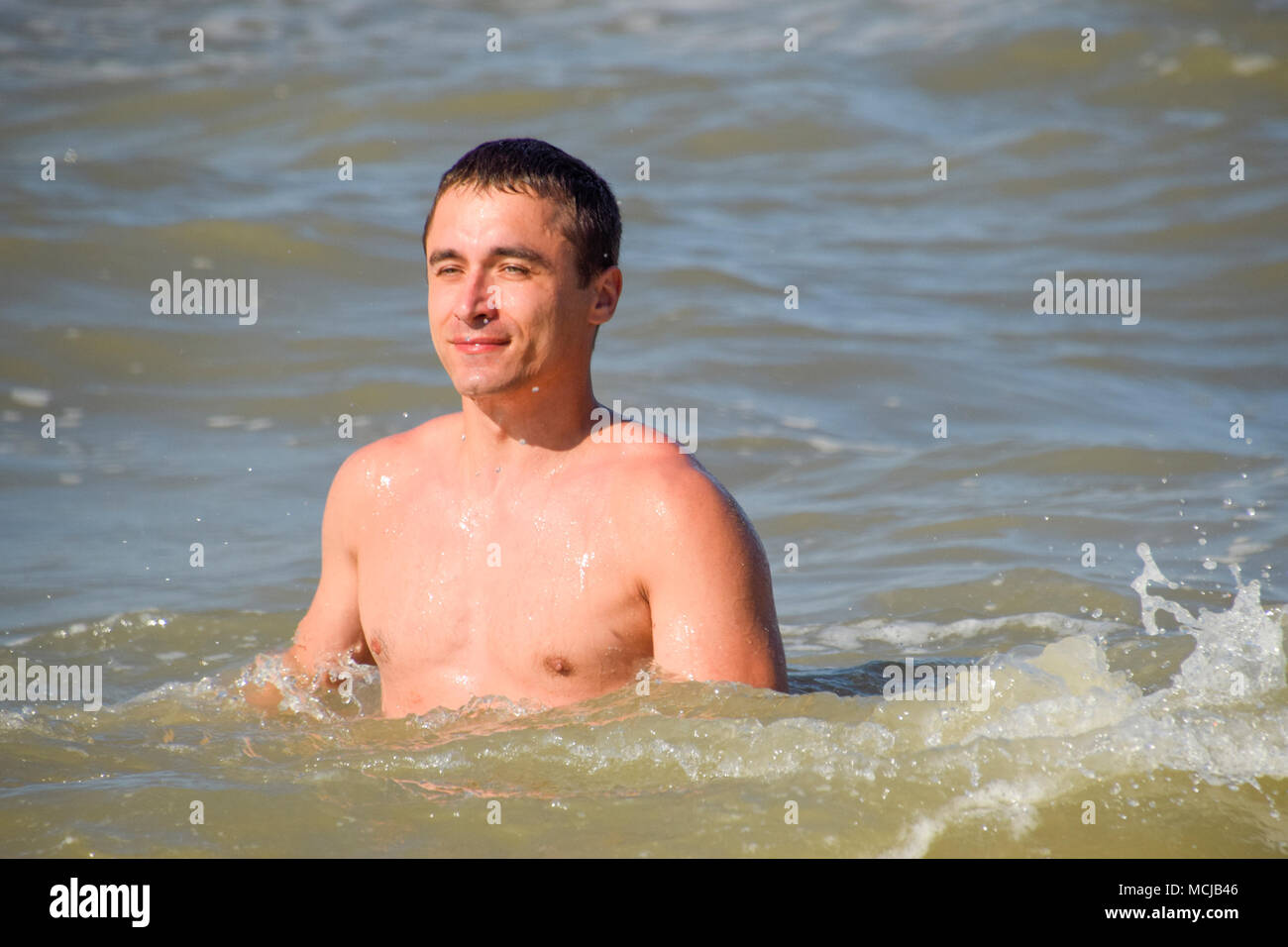 Athletic man in sea water. Bathing in the sea. A man is swimming among ...